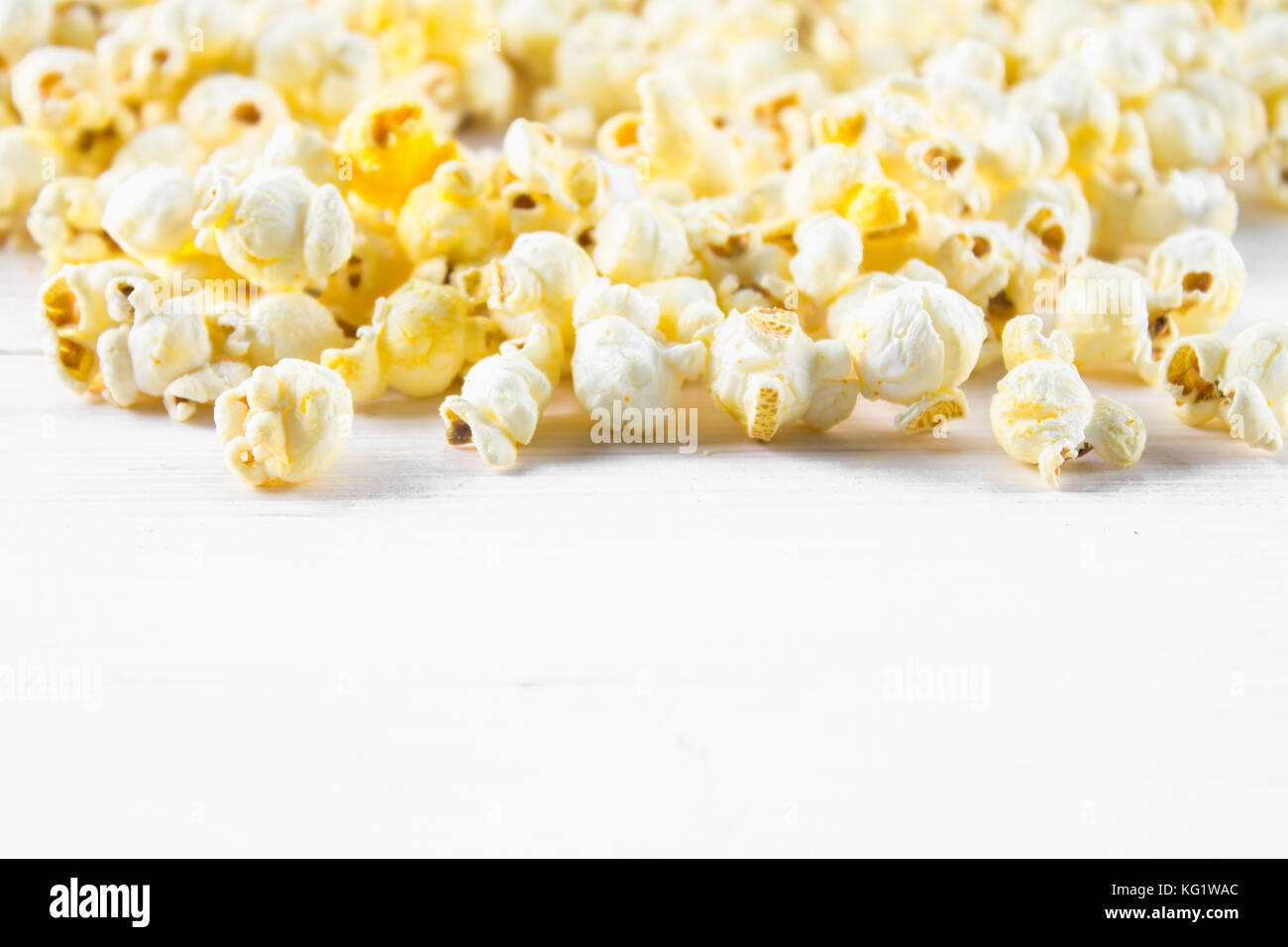 Salted popcorn on a white table. Top view. Empty space for text Stock ...
