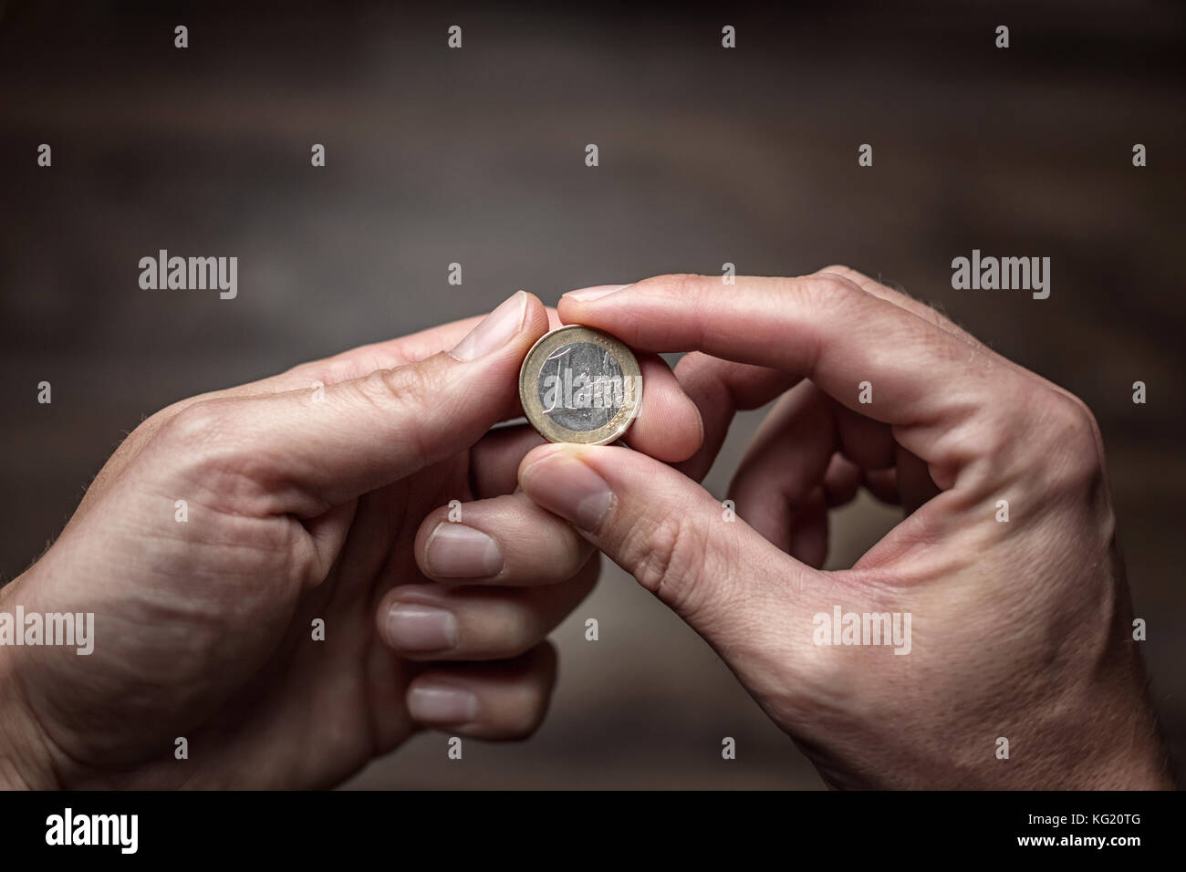 Euro coin held by two hands Stock Photo - Alamy