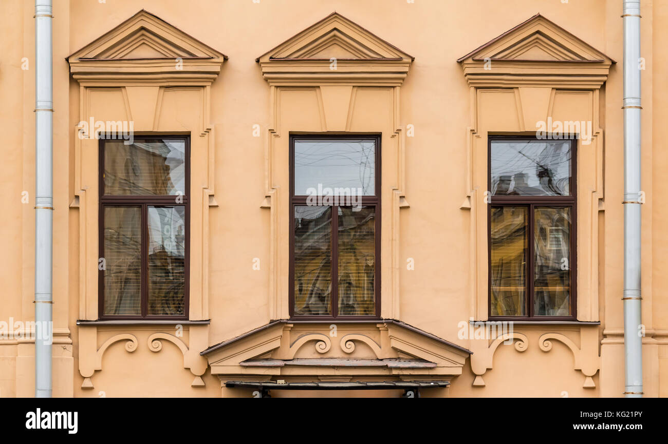 Three windows in a row on facade of urban apartment building front view ...