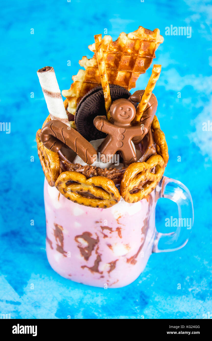 Freakshake from pink smoothie, cream. Monstershake with a chocolate man ...