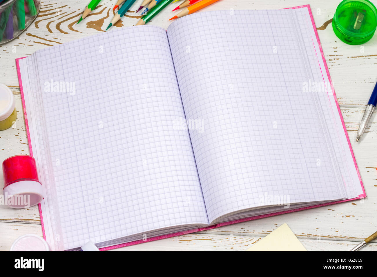Outdoor notebook surrounded by school supplies on a white wooden ...