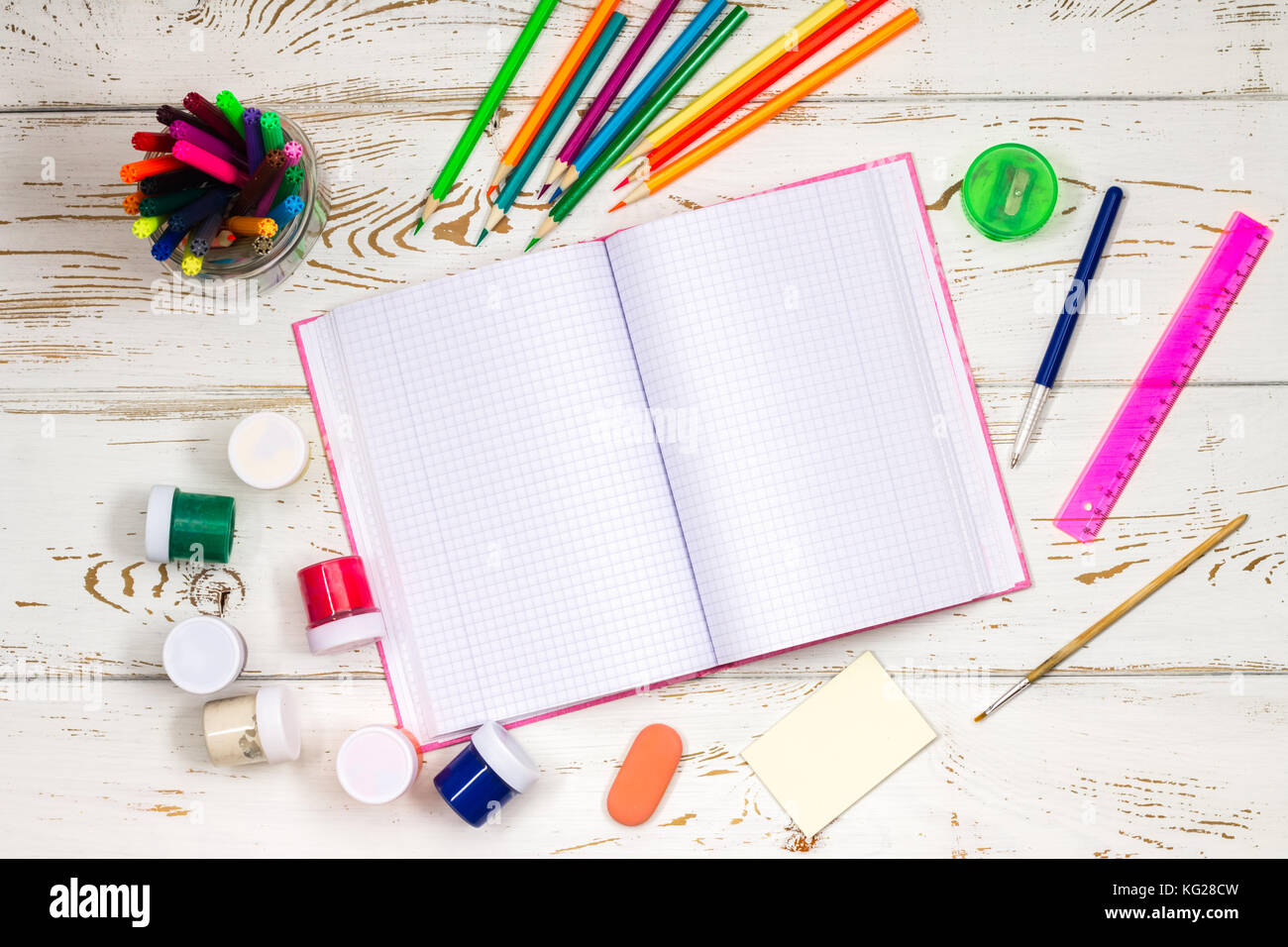 Outdoor notebook surrounded by school supplies on a white wooden ...