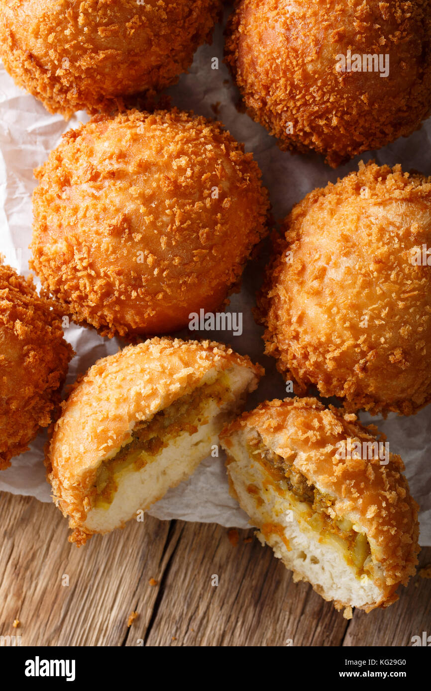Japanese cut Kare-pan in breadcrumbs macro on the table. Vertical top ...