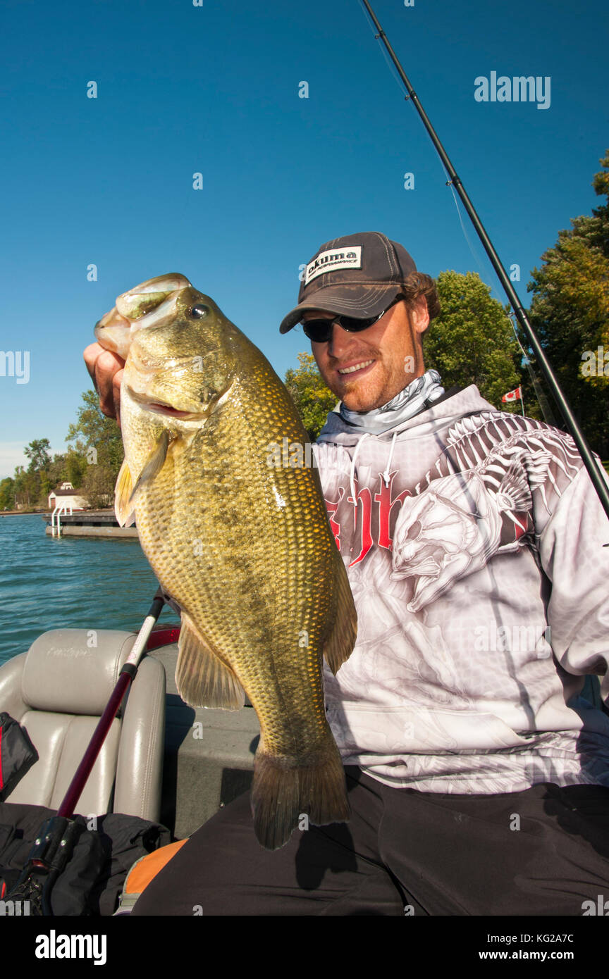 Smiling man hoisting largemouth Bass from bass boat Stock Photo - Alamy