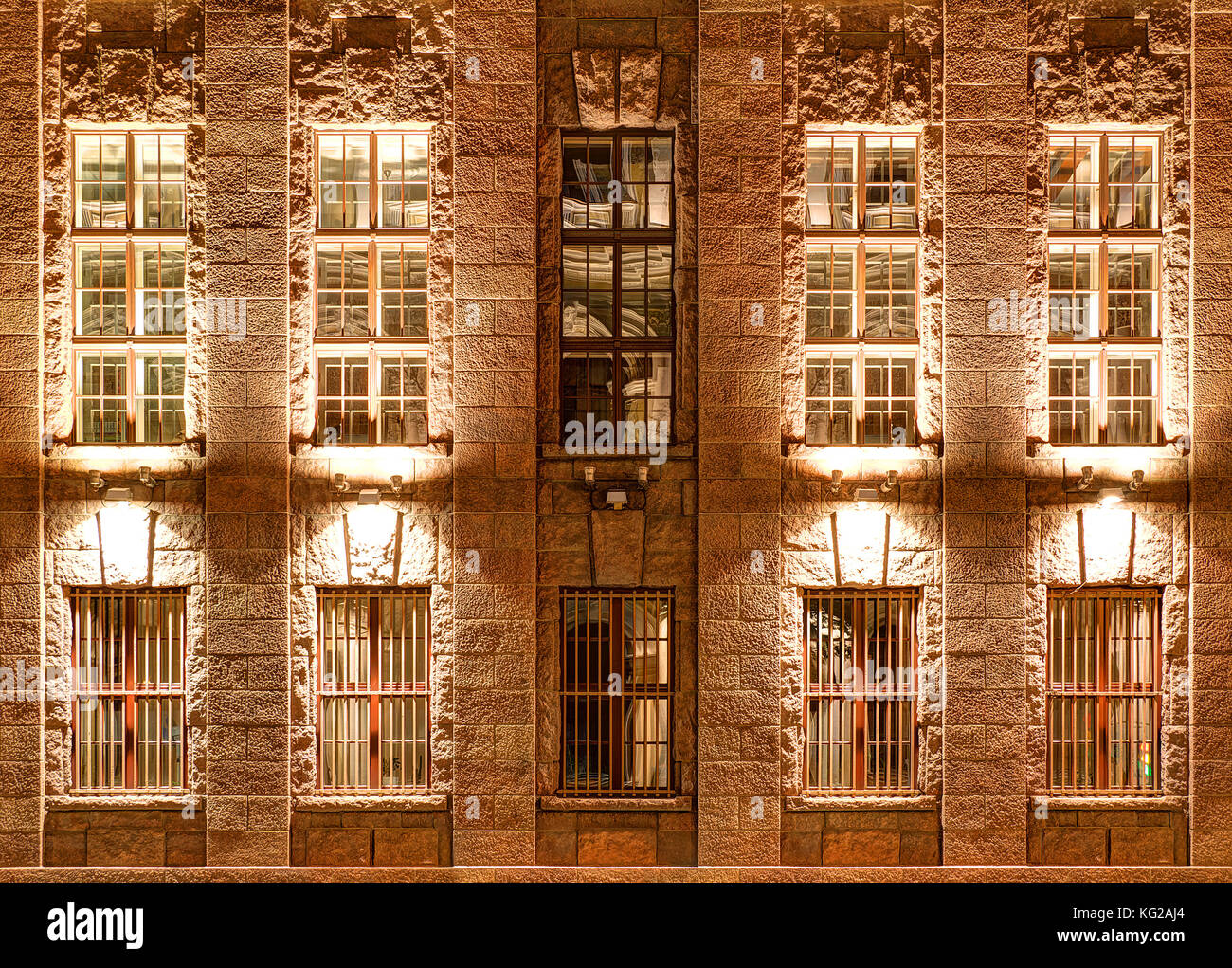 Several windows in a row on night illuminated facade of urban office ...