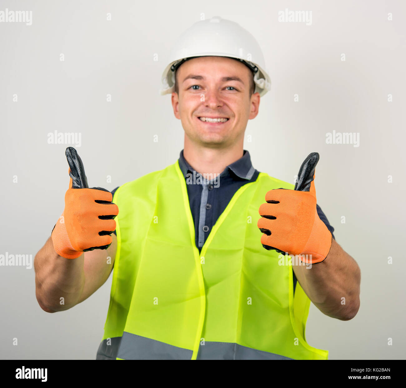 Builder in a helmet and vest Stock Photo - Alamy