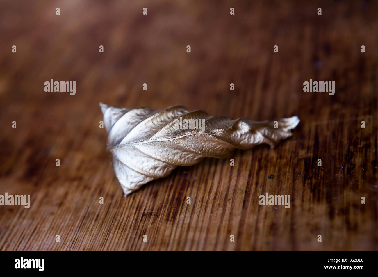 gold leaf on wooden table Stock Photo - Alamy