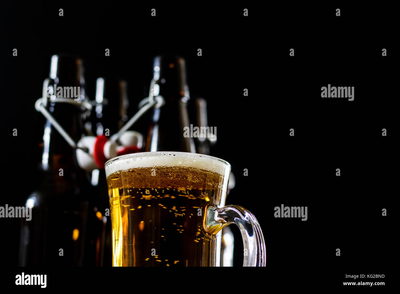 A pint of tasty beer on a wooden table. Beer in pint and beer bottles ...
