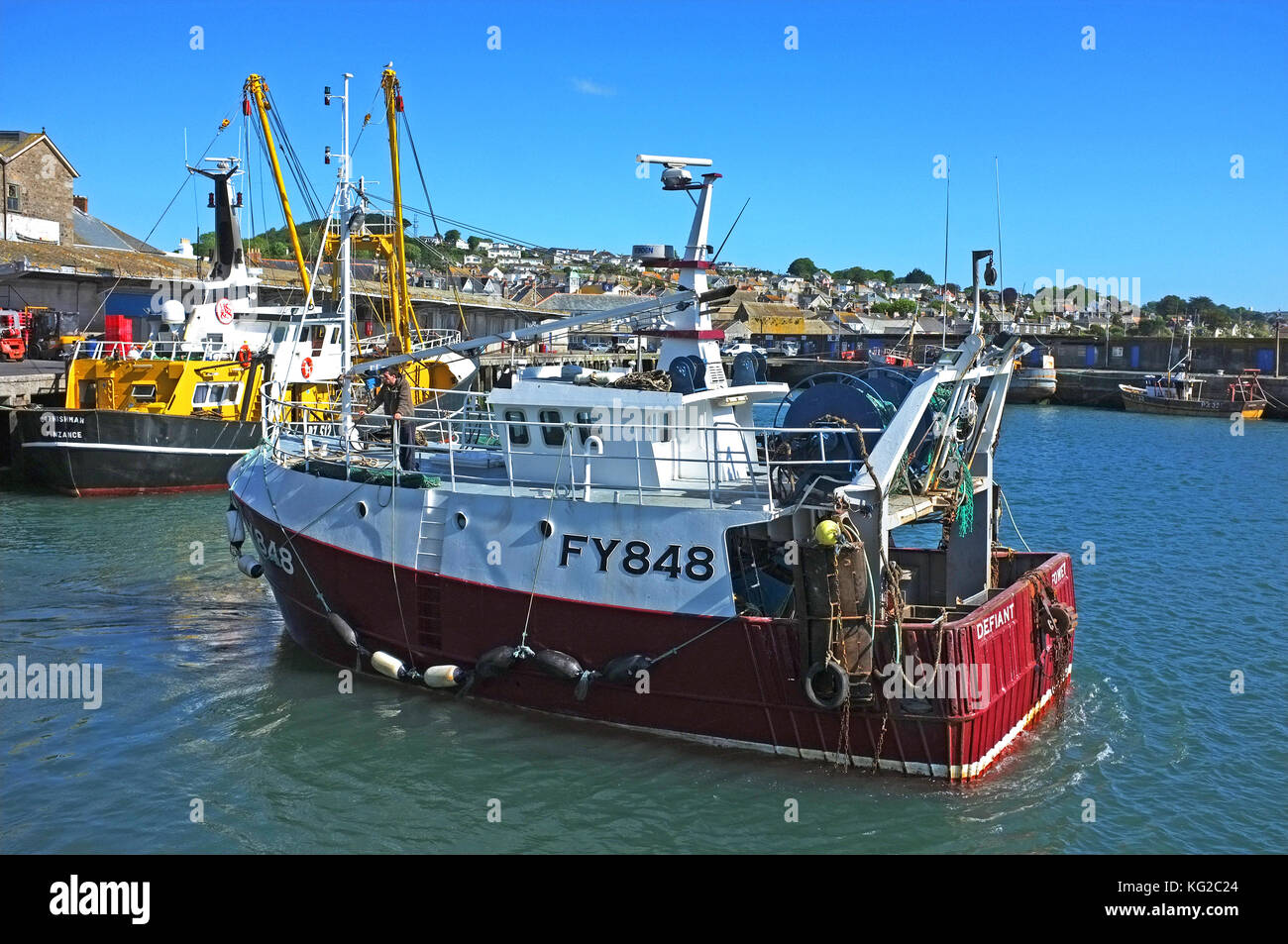 a fishing trawler coming in to harbour at newlyn, cornwall, england ...