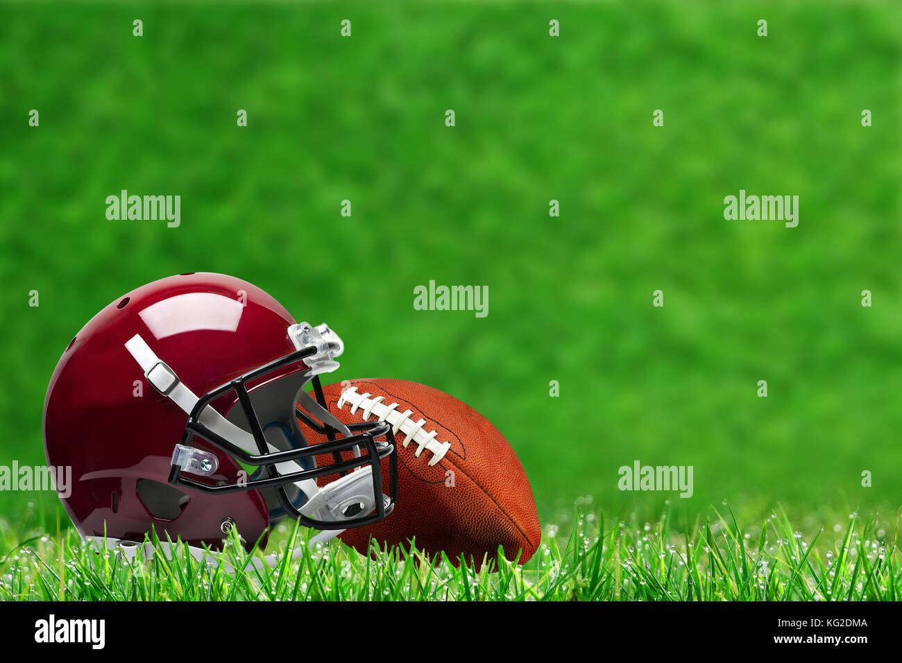 Low angle view of football helmet and ball on field grass and ...