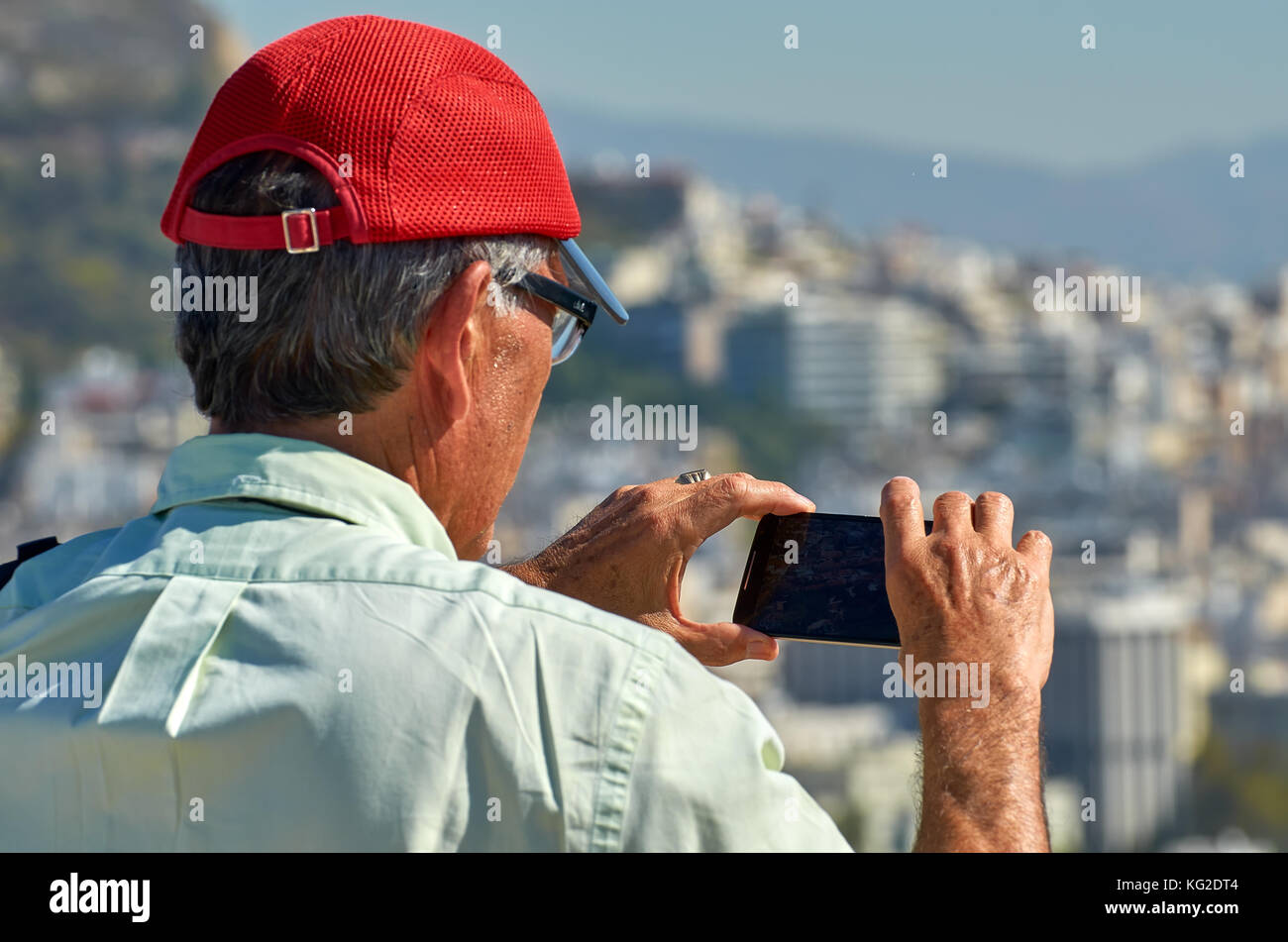 Man taking a picture of Athens from the hill of the Acropolis Stock ...