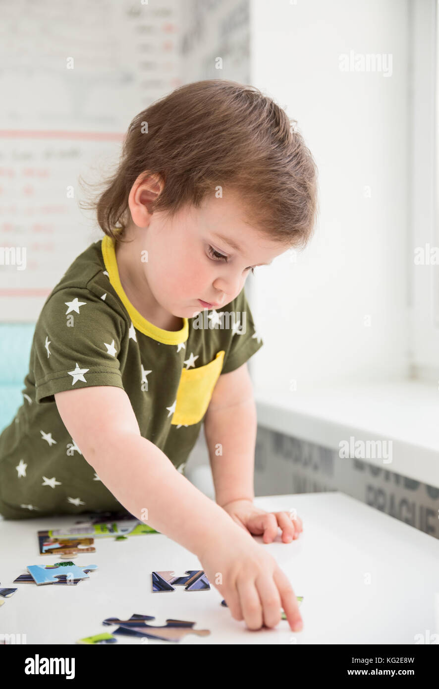 Cute baby boy or toddler playing with a puzzle, child development ...