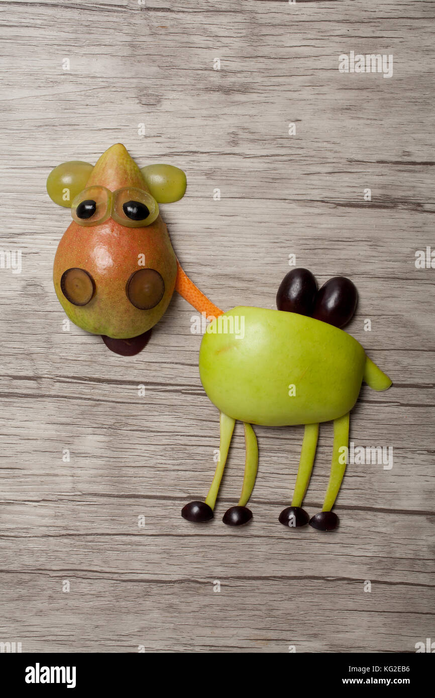 Happy camel made with fruits on wooden background Stock Photo - Alamy