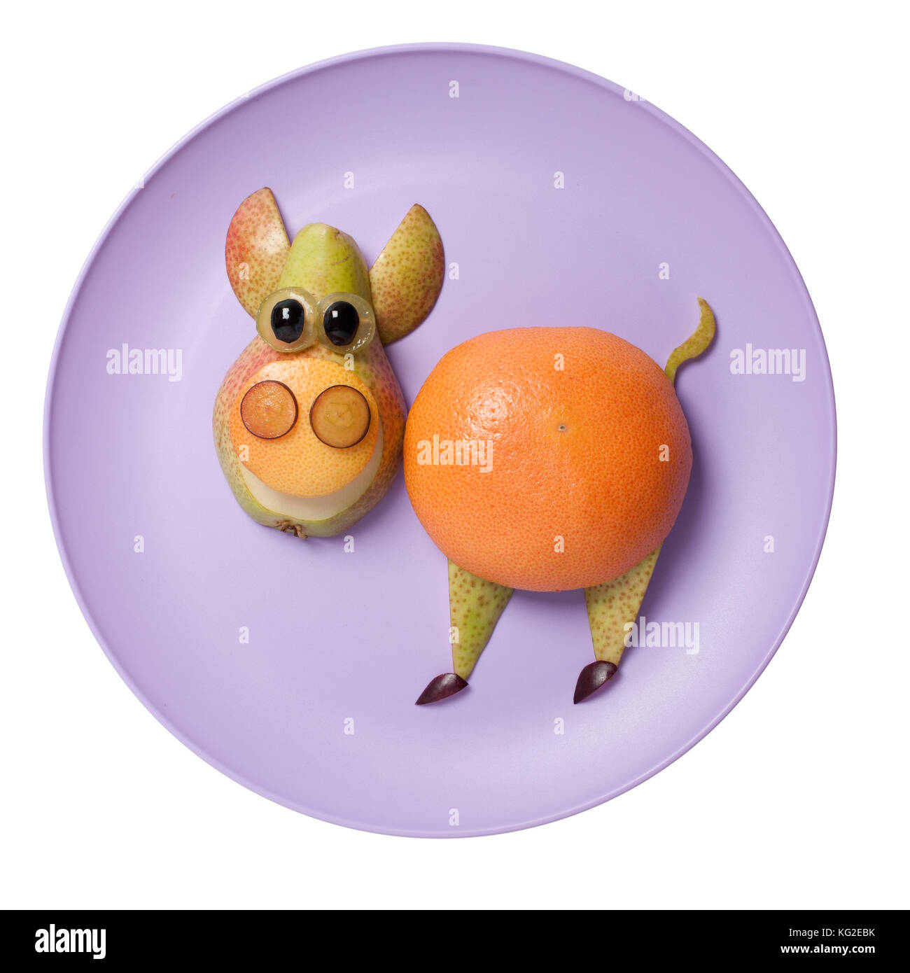 Funny fruit pig made on purple plate Stock Photo - Alamy