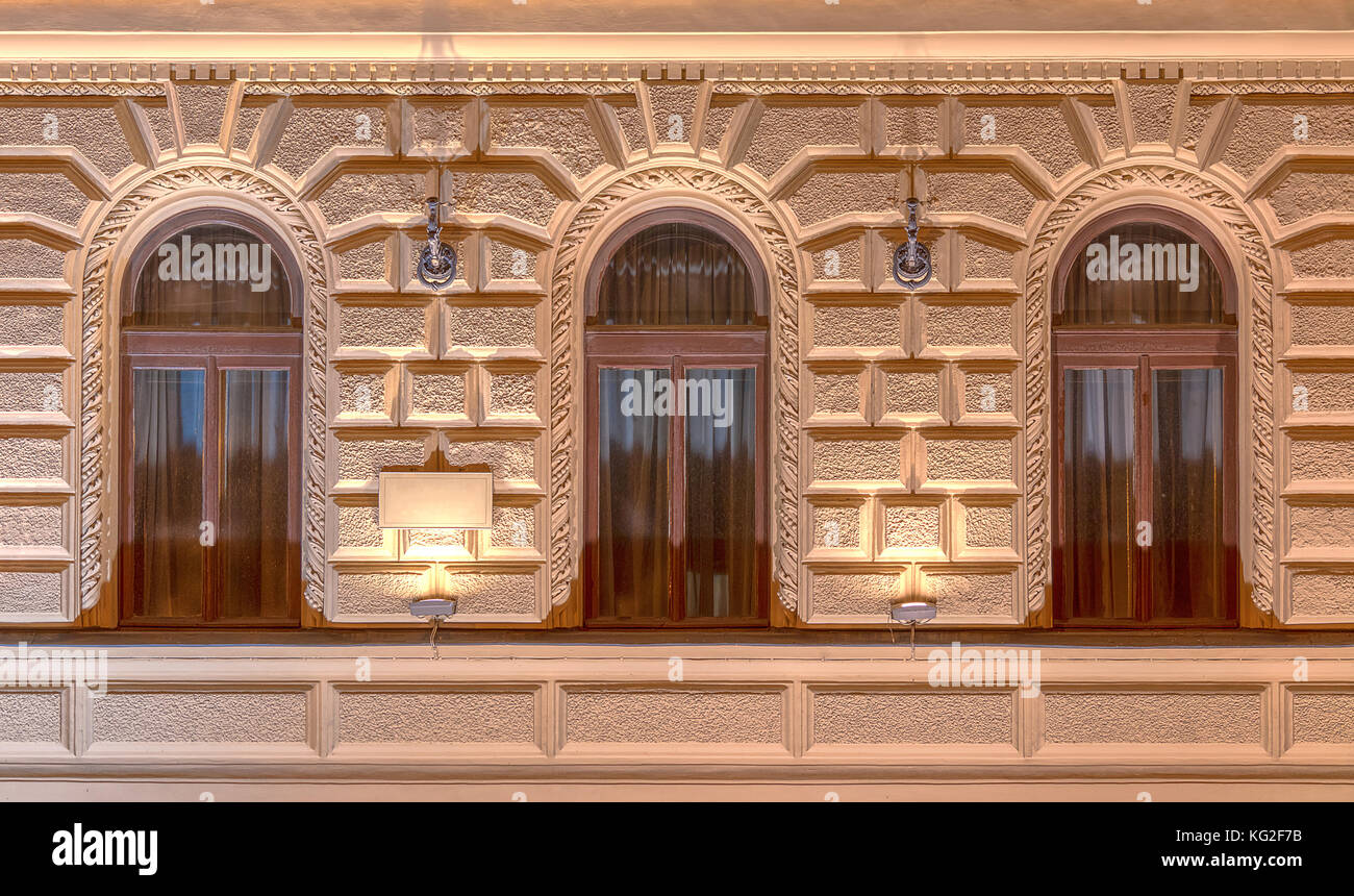 Three windows in a row on night illuminated facade of urban office ...