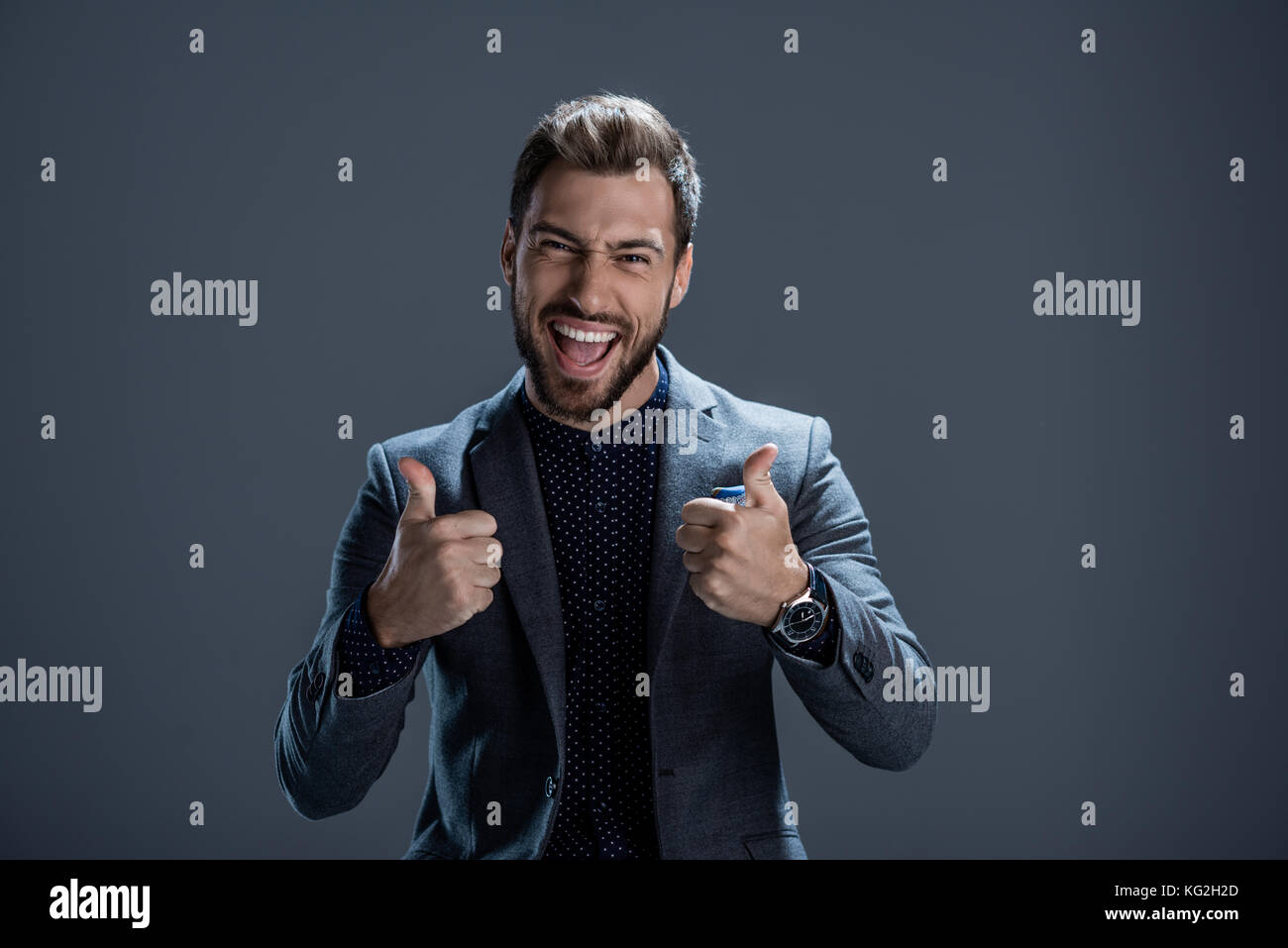 Man in suit showing thumbs up Stock Photo - Alamy