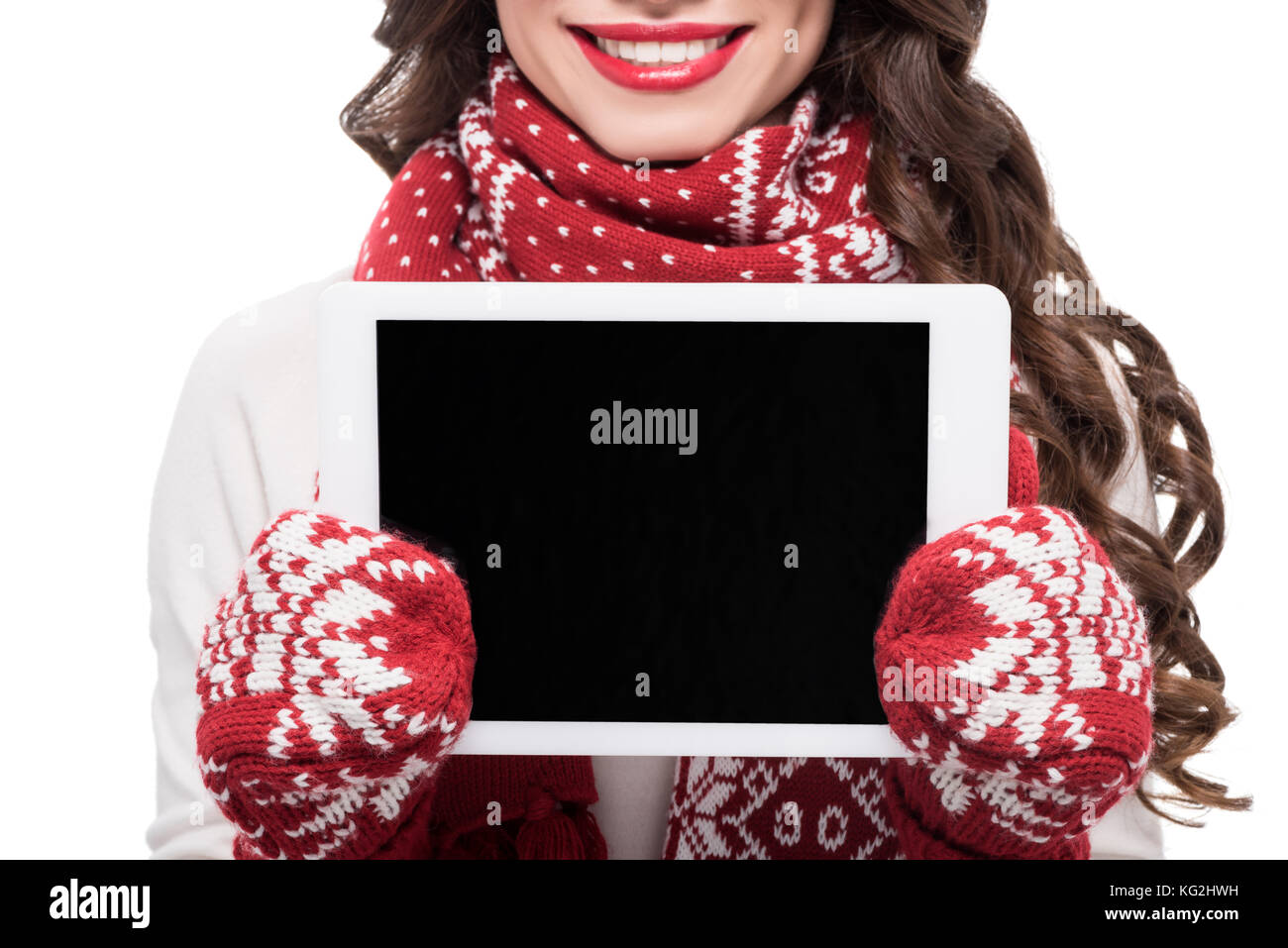 Woman in winter clothes showing tablet Stock Photo - Alamy