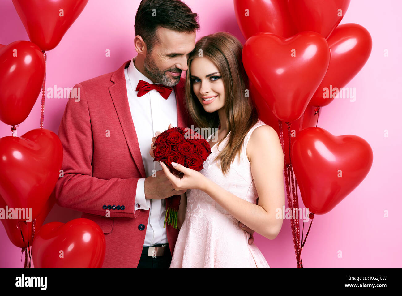 Man giving roses and embracing his girlfriend Stock Photo - Alamy