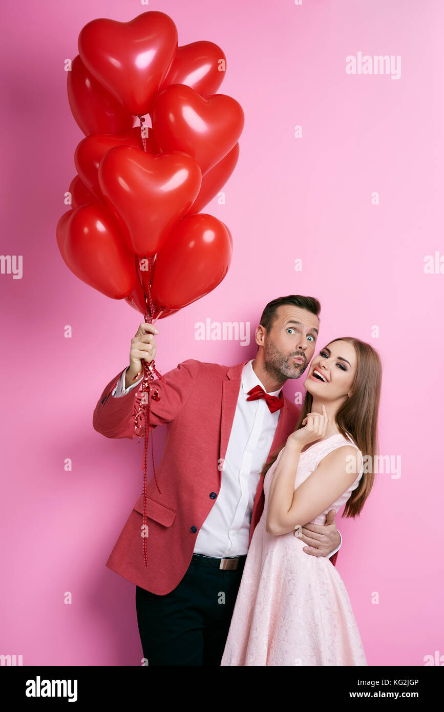 Affectionate couple with heart shape balloons flirting Stock Photo - Alamy