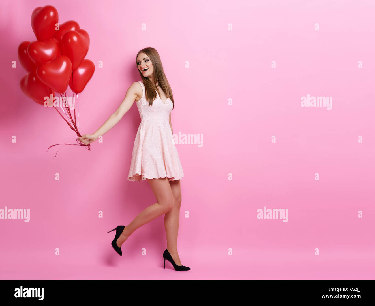 Woman pulling bunch of balloons Stock Photo - Alamy