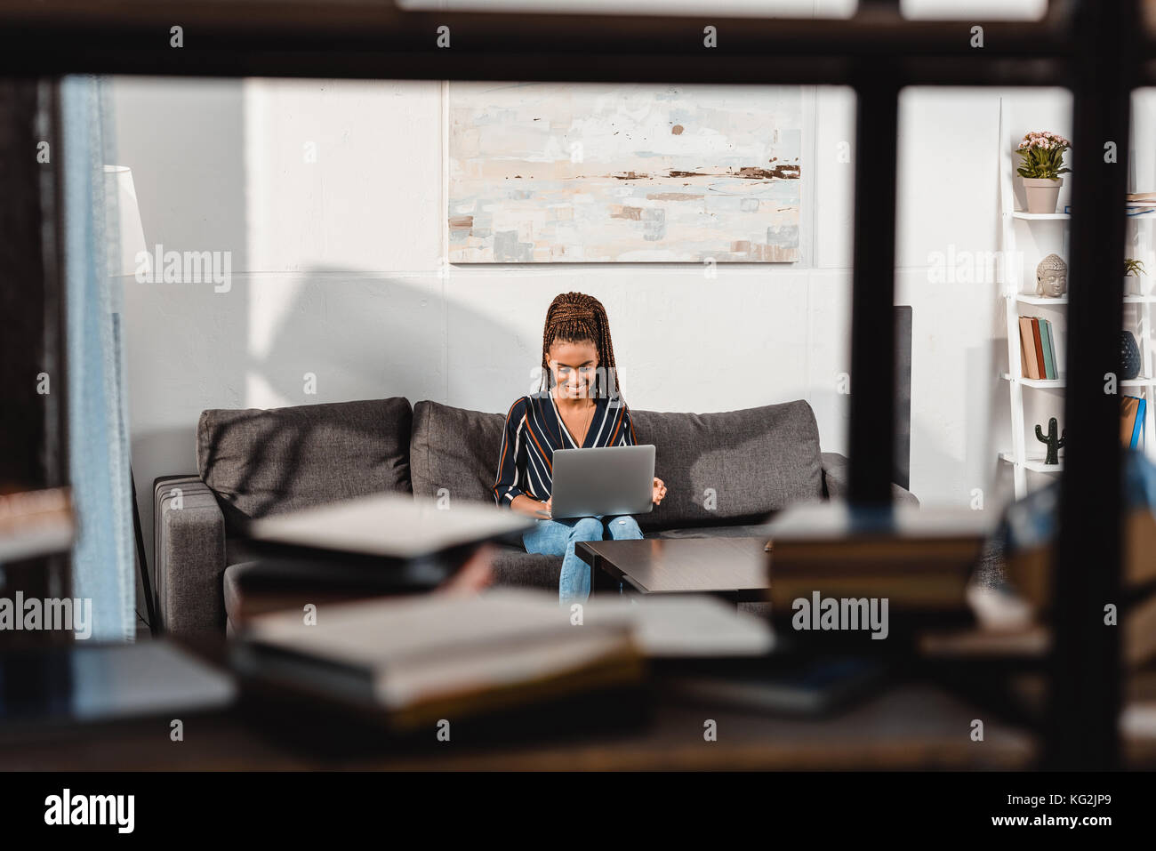 woman using laptop on couch Stock Photo - Alamy