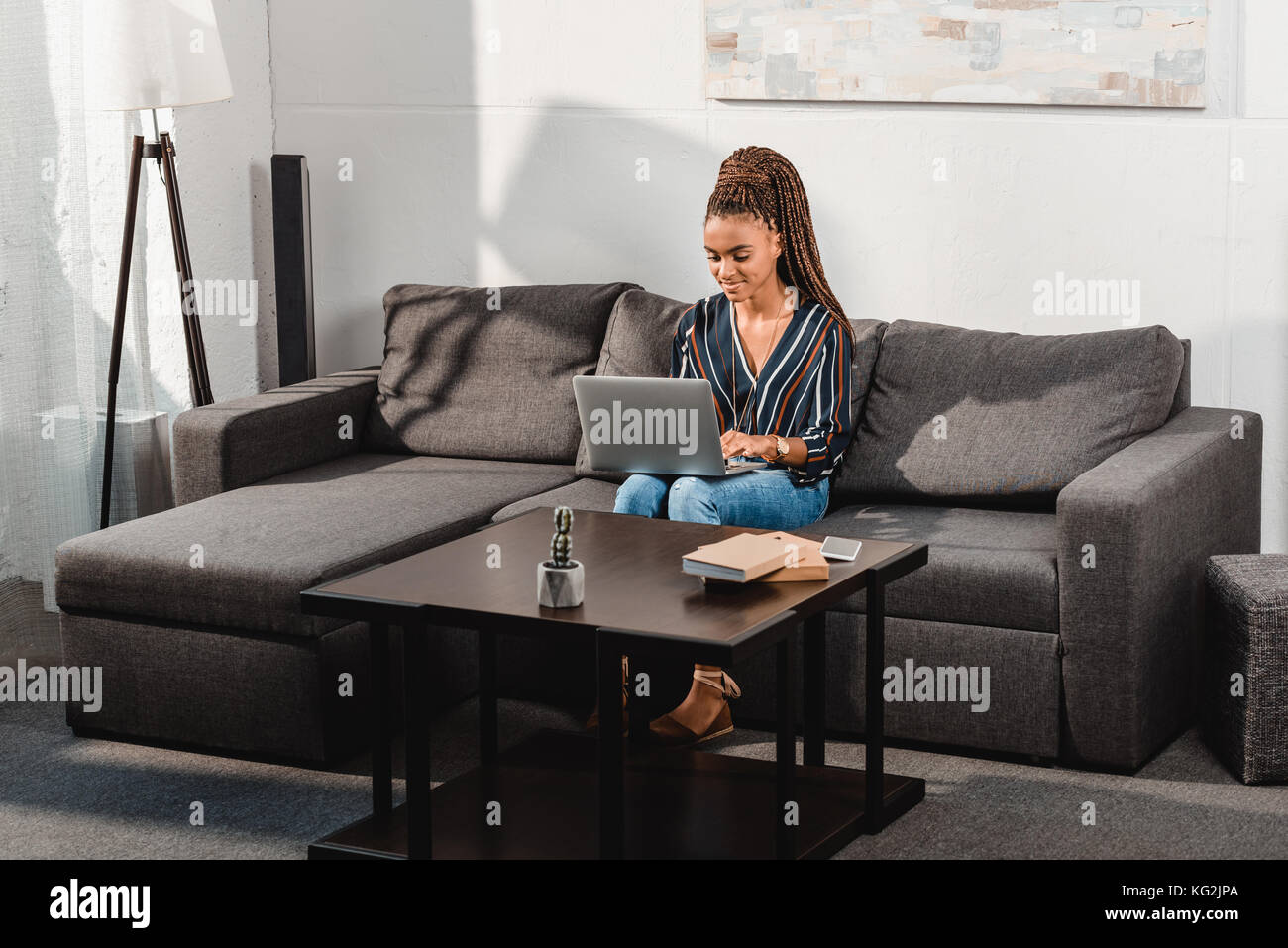 woman using laptop on couch Stock Photo - Alamy