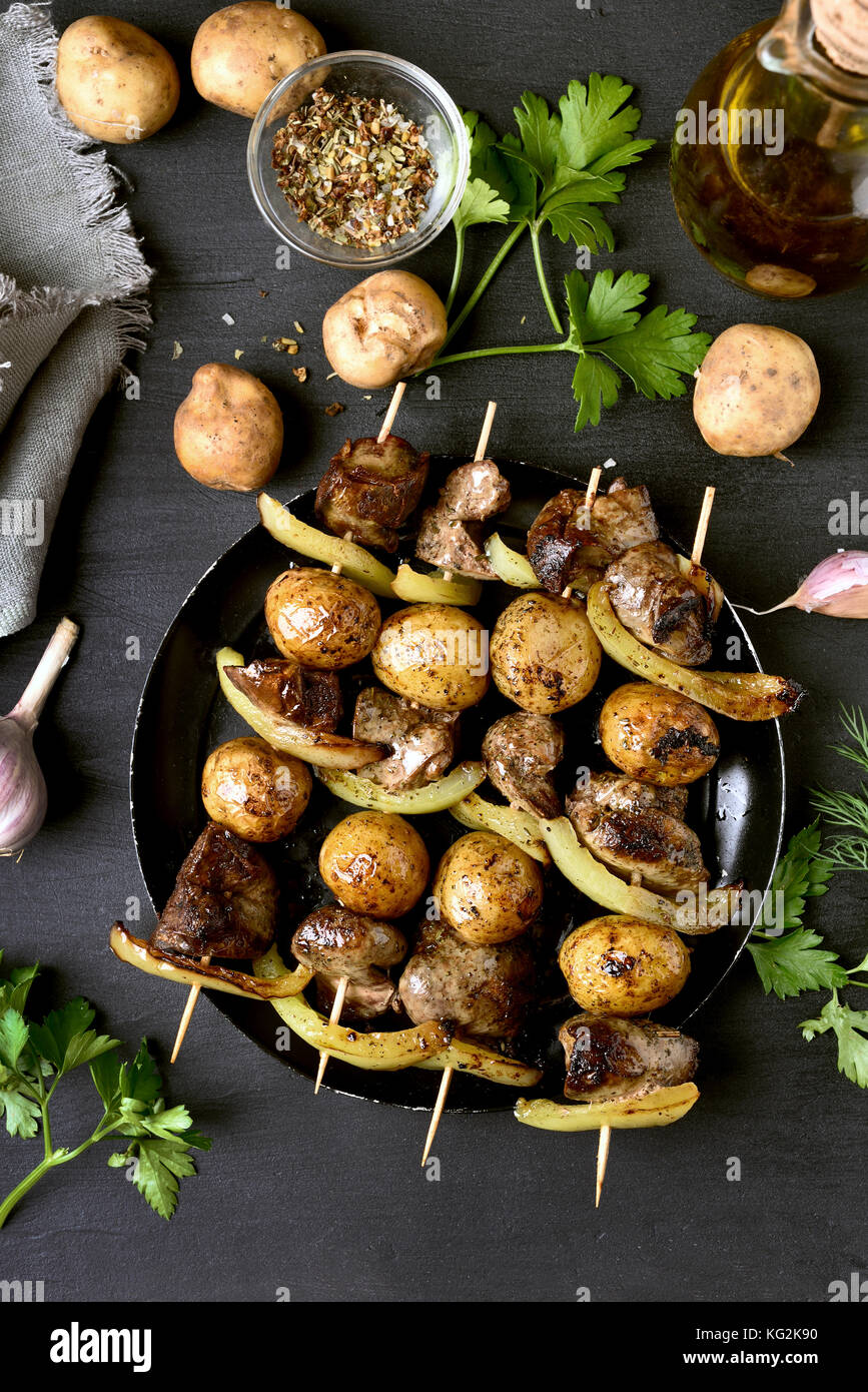 Barbecue chicken liver, vegetables skewers on black background, top ...