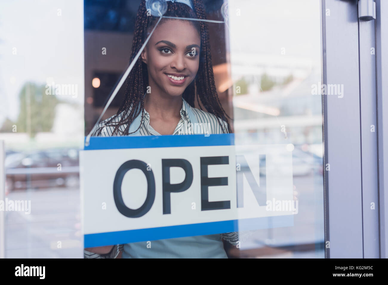 Employee hanging open sign on door Stock Photo - Alamy