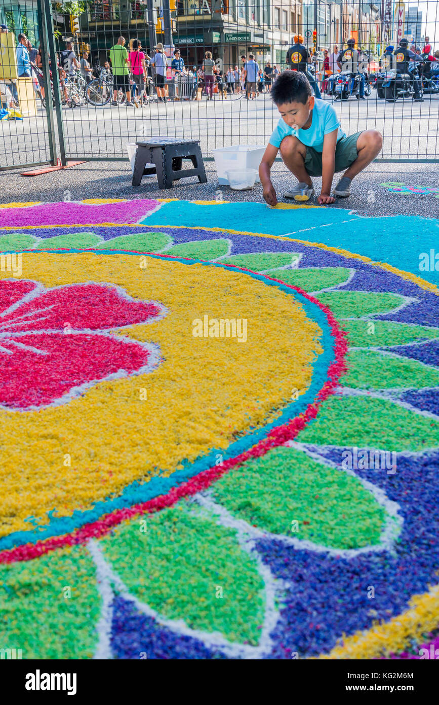 Boy adding rice to large mandala Rangoli floor decoration India Live ...