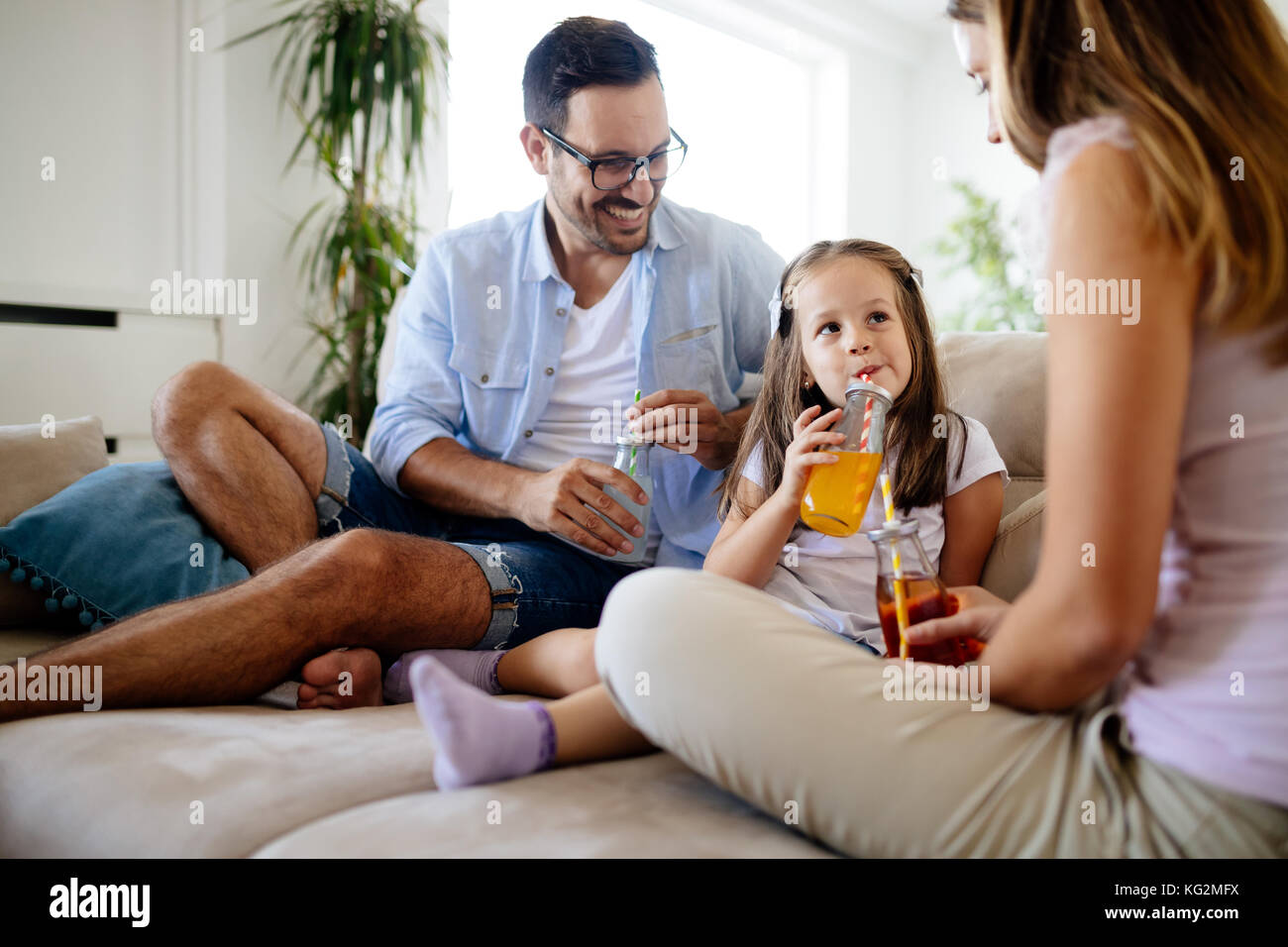 Happy family drinking juice together in their house Stock Photo - Alamy