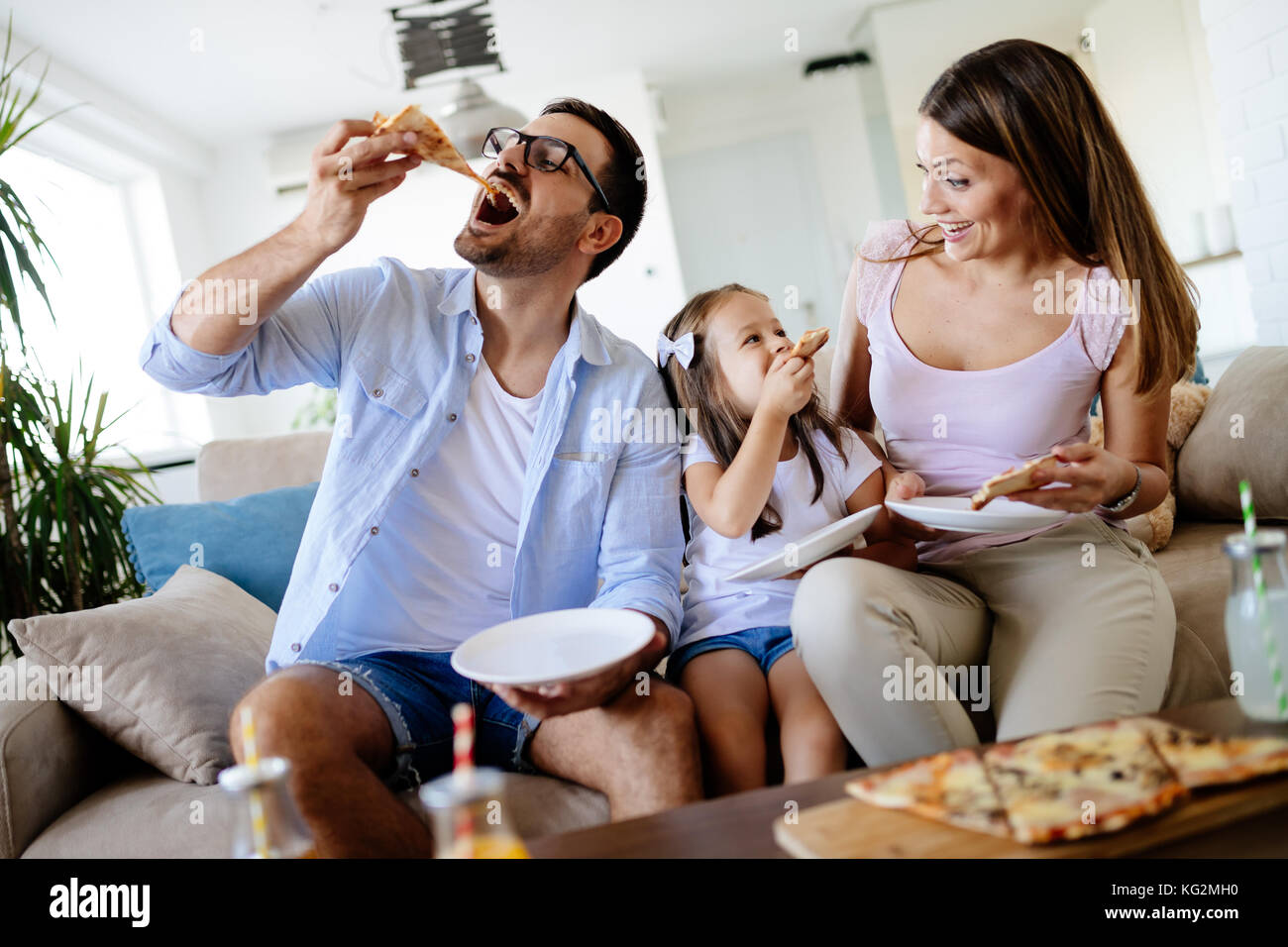 Happy family sharing pizza together at home Stock Photo - Alamy