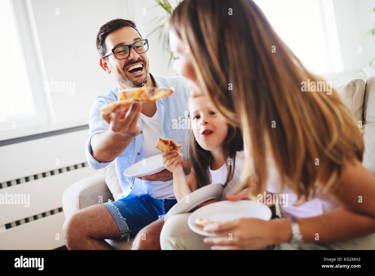Happy family sharing pizza together at home Stock Photo - Alamy