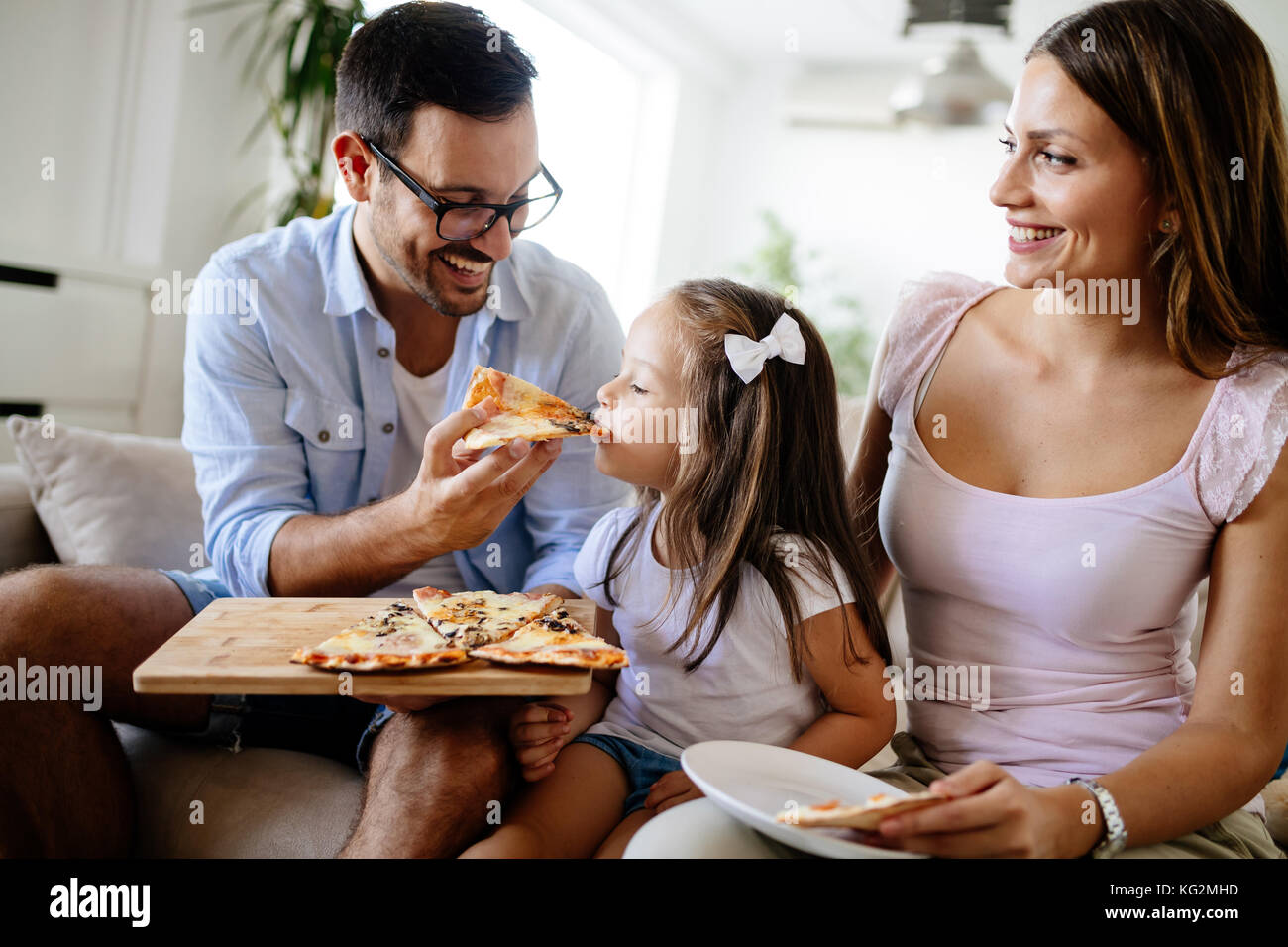 Happy family sharing pizza together at home Stock Photo - Alamy