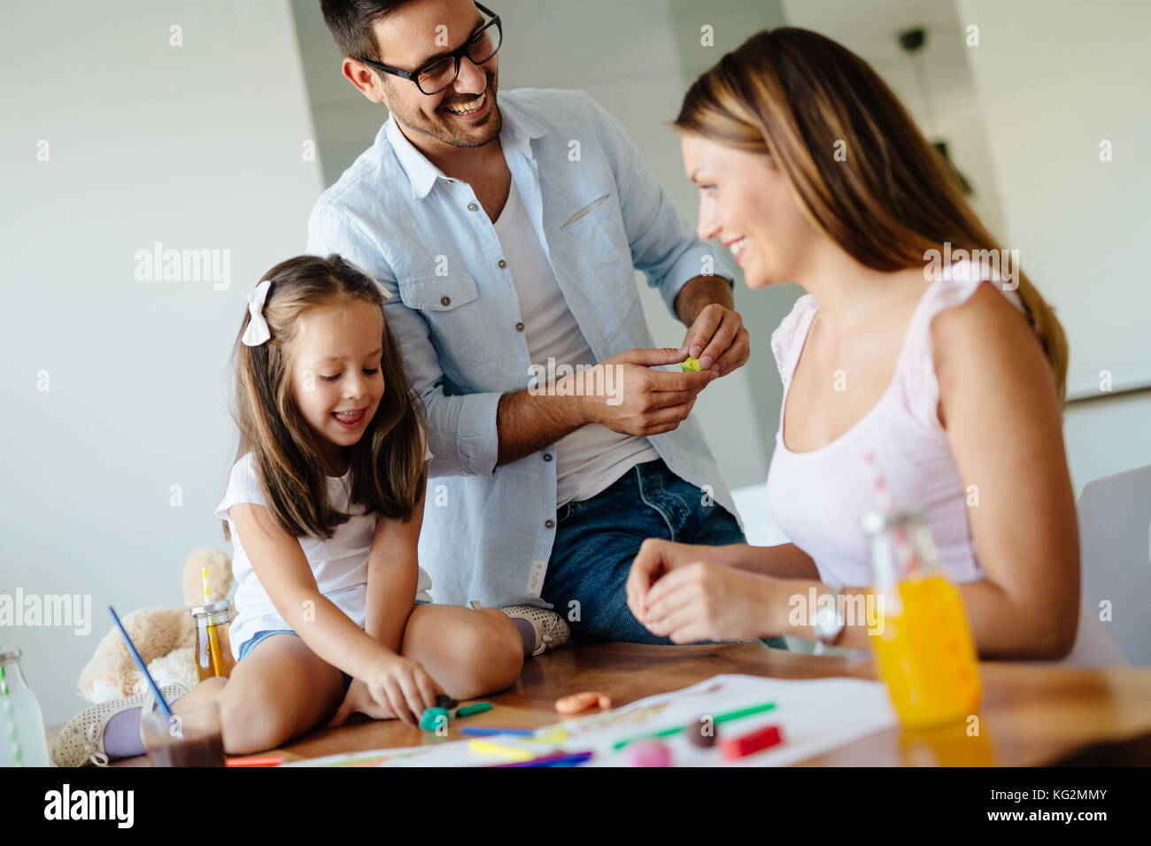 Little girl doing art work with her parents Stock Photo - Alamy
