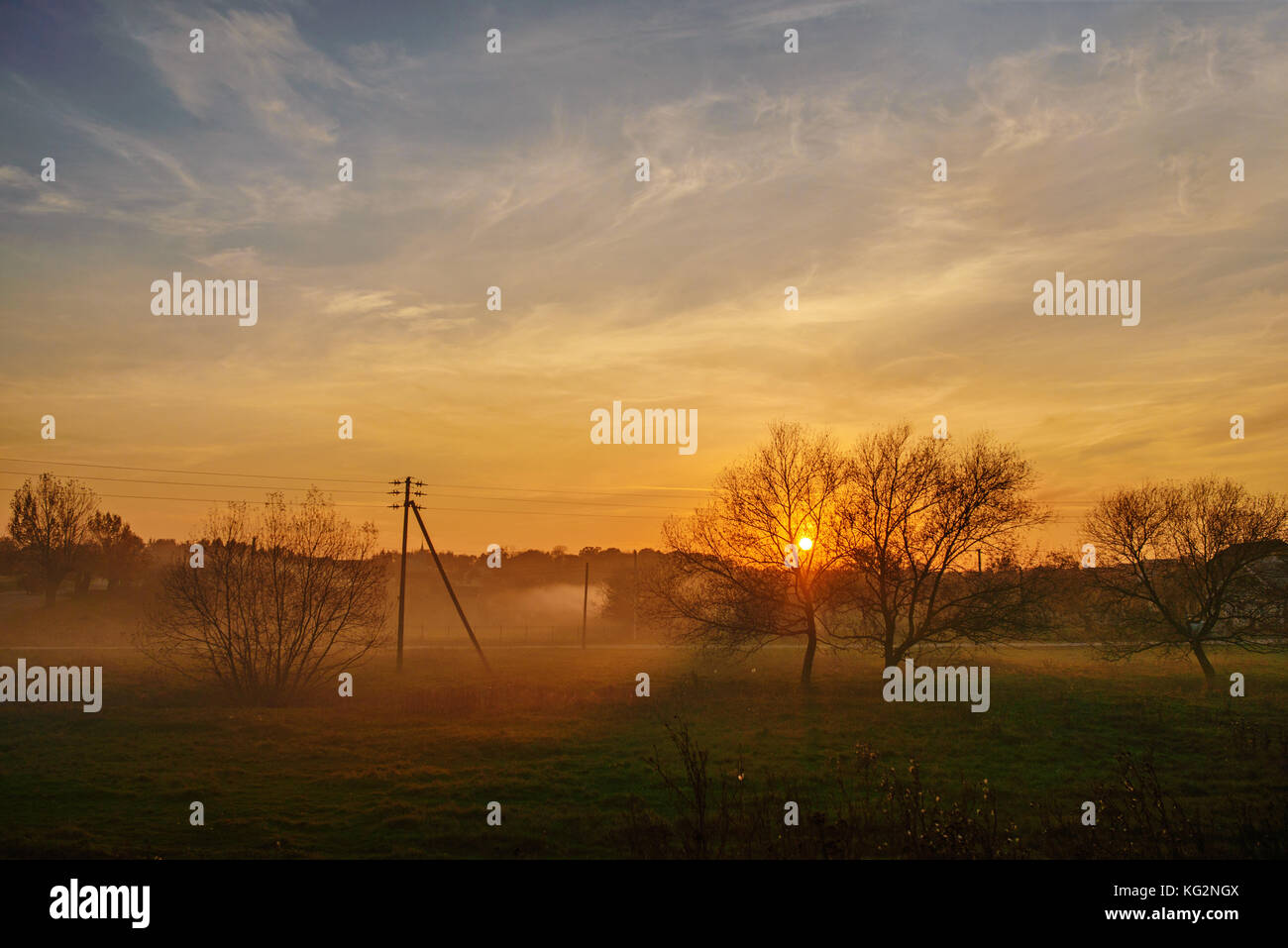 An landscape of autumn and foggy countryside greenfield with village on ...
