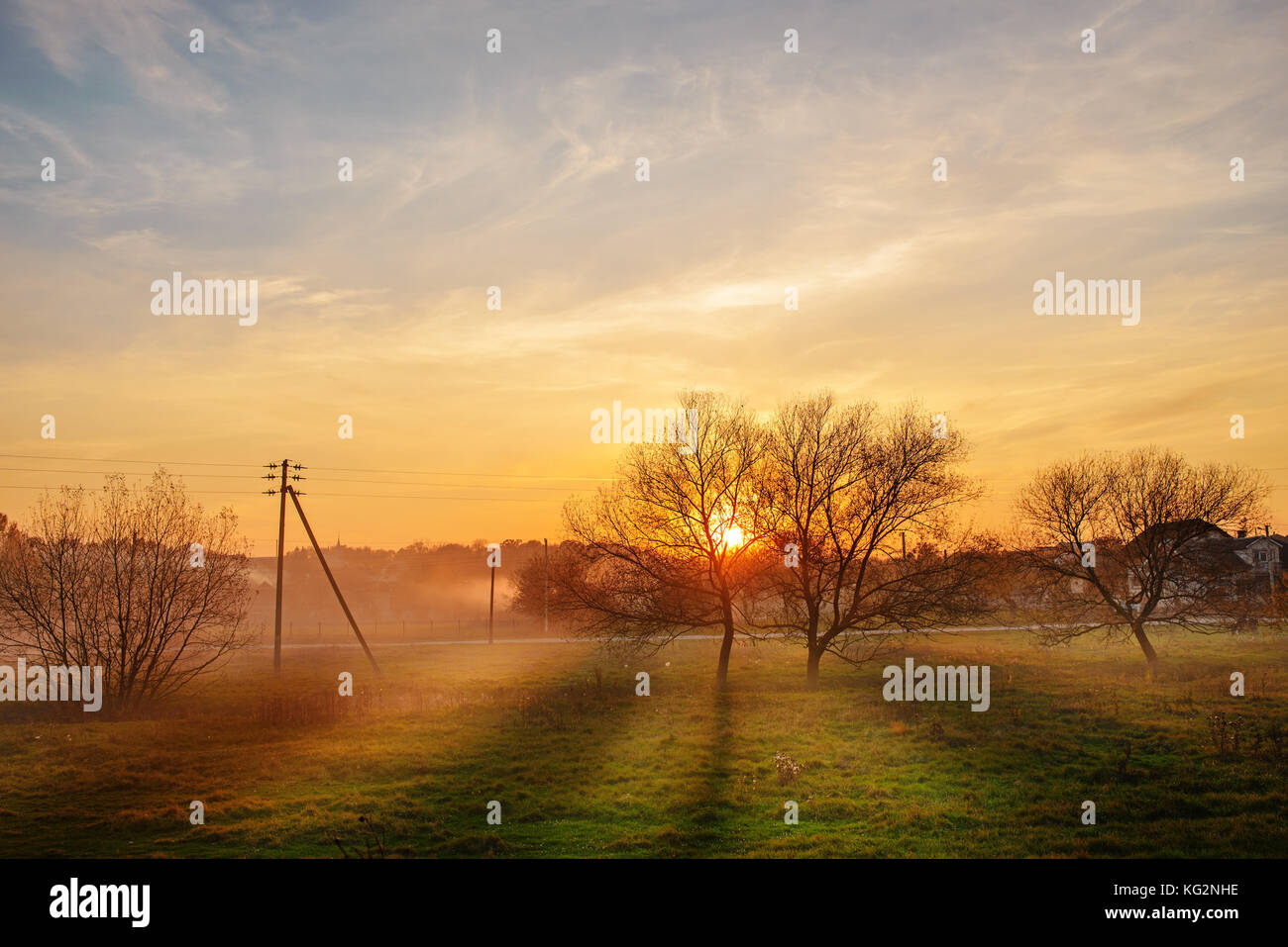 An landscape of autumn and foggy countryside greenfield with village on ...