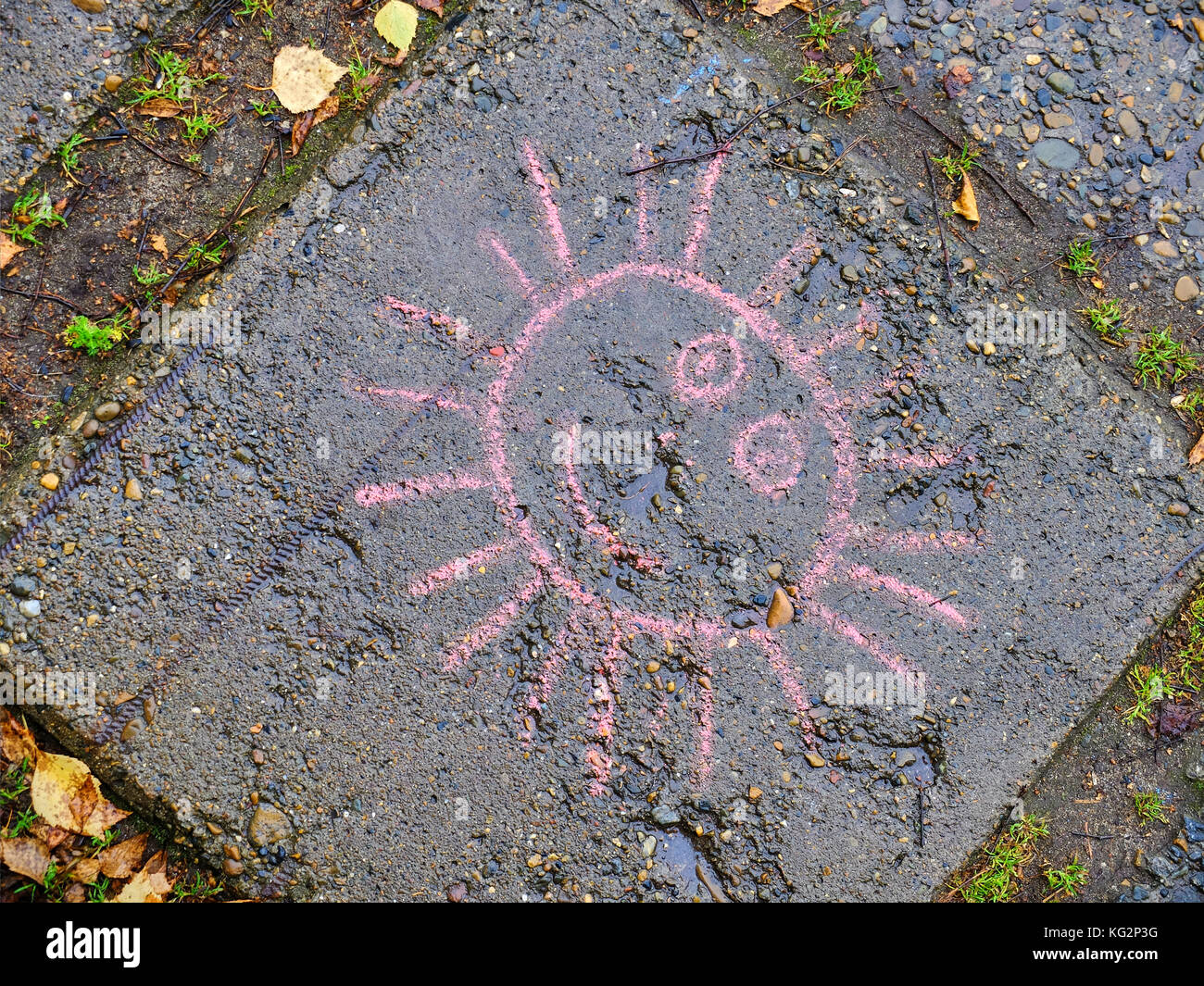 Child's chulk painting of a pink sun on the wet asphalt Stock Photo - Alamy