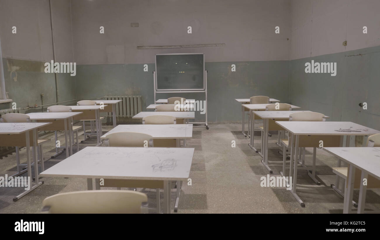 Empty classroom with wooden desks, white and green chalk boards in ...