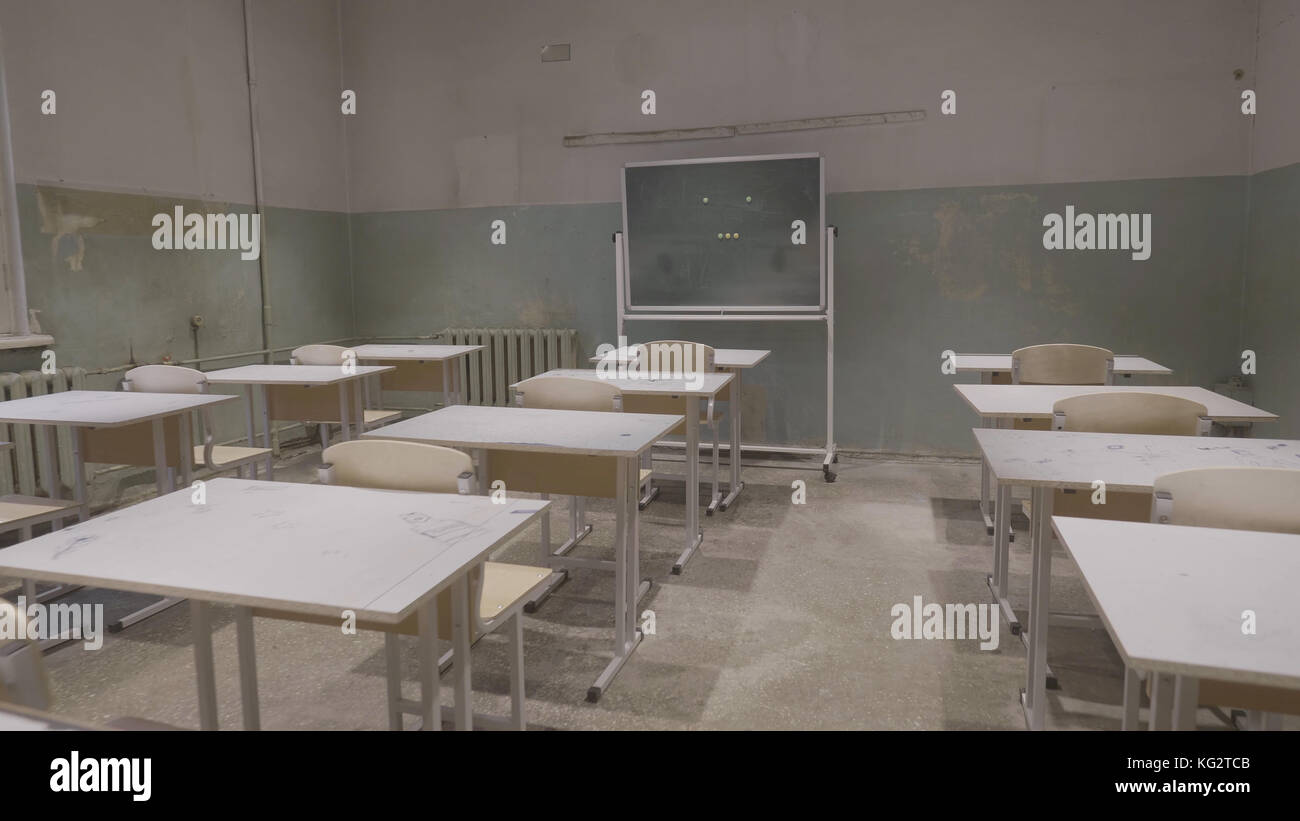 Empty classroom with wooden desks, white and green chalk boards in ...
