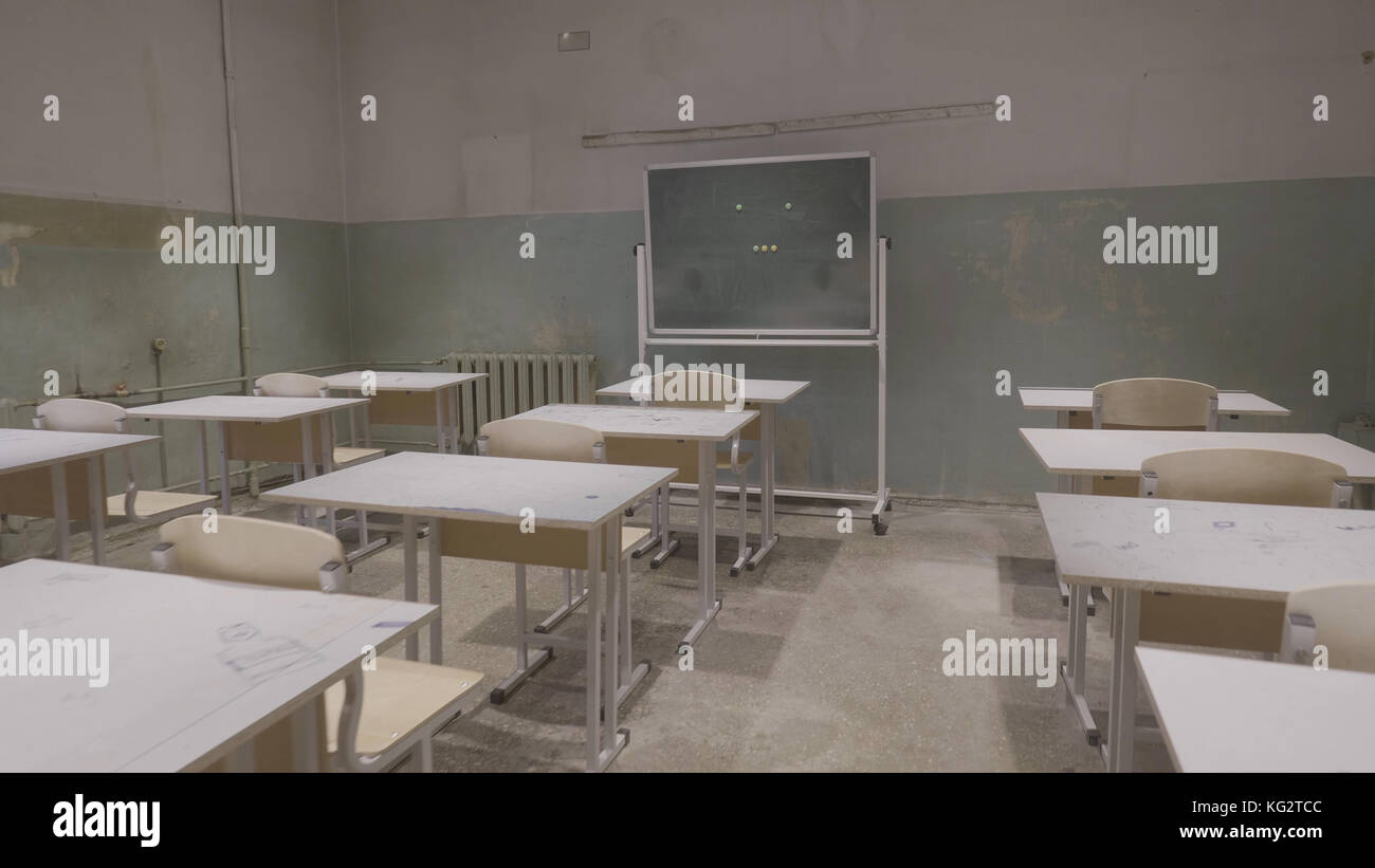 Empty classroom with wooden desks, white and green chalk boards in ...