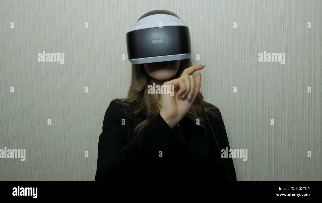 Woman using finger to touch on imaginary panel viewing on VR device ...