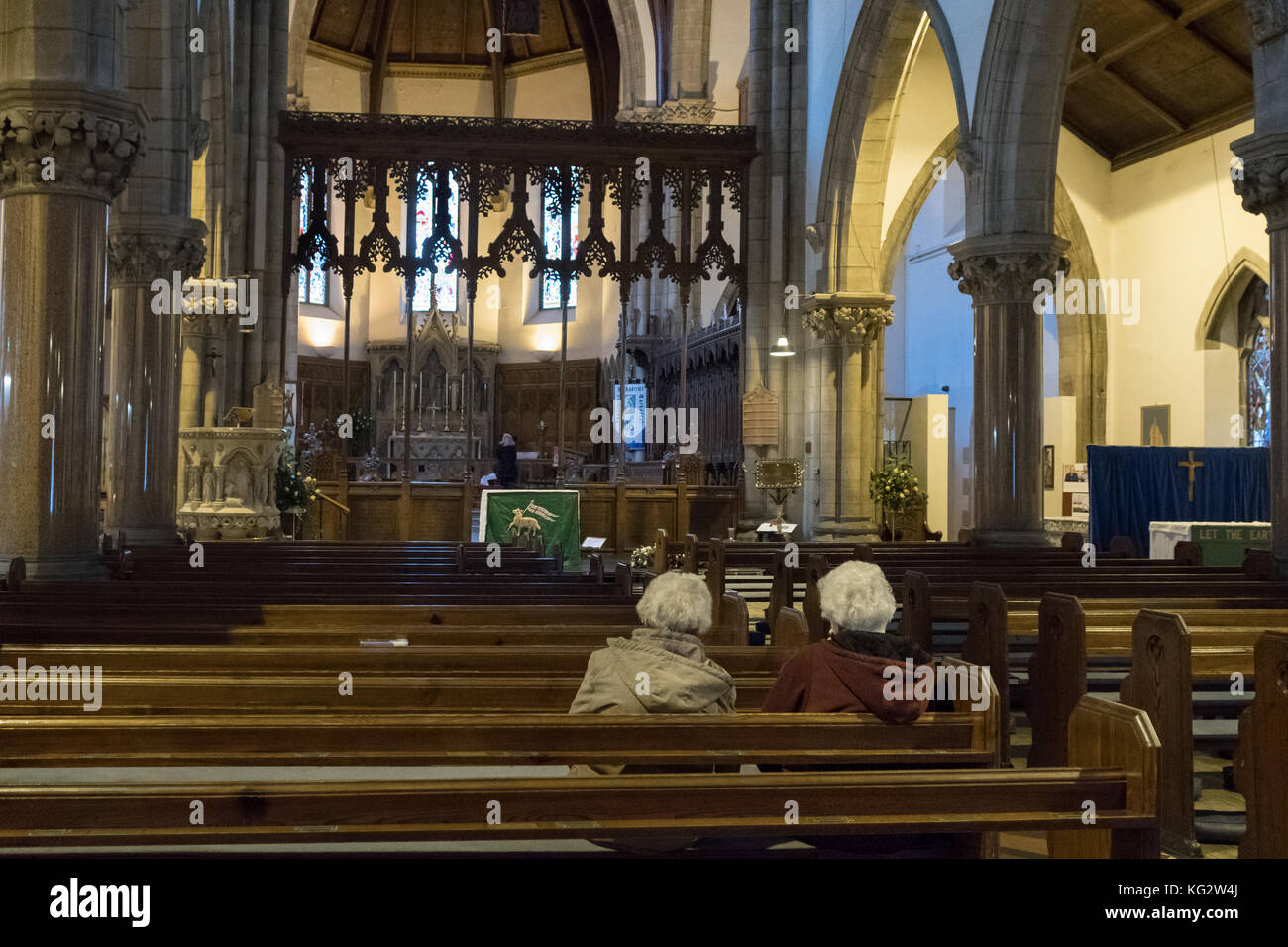 two elderly ladies sitting in empty pews in Inverness Cathedral ...