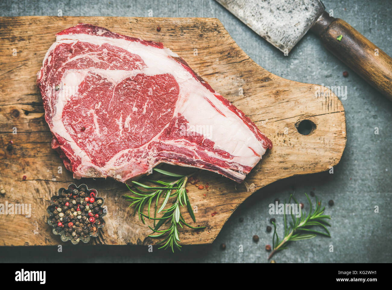 Raw uncooked beef steak rib-eye on board with seasoning Stock Photo - Alamy