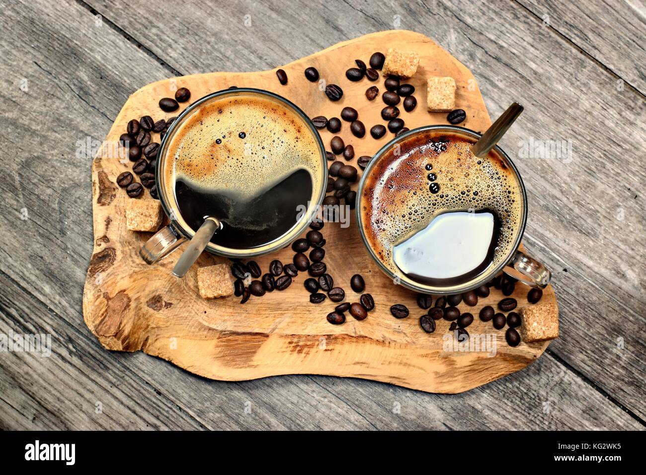 Two cups of coffee,coffee beans and brown lump sugar on wooden ...