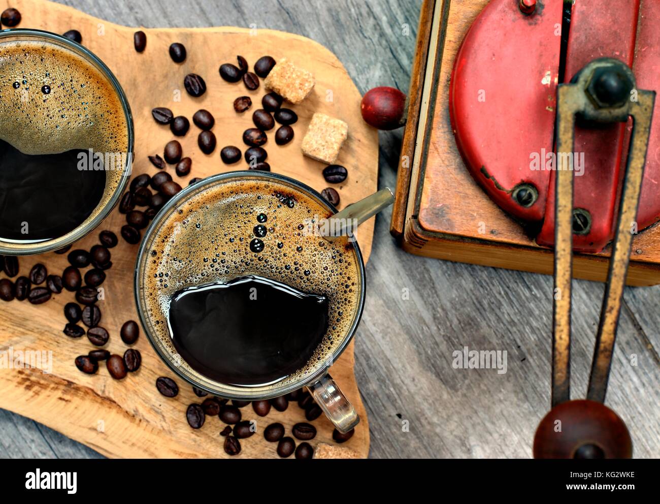 Two cups of coffee,coffee beans,brown lump sugar and coffee grinder on ...