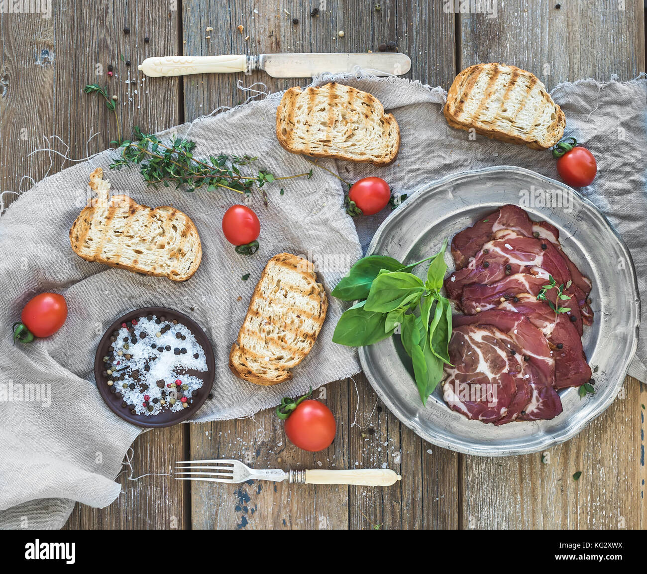 Smoked meat in vintage silver plate with fresh basil, cherry-tomatoes ...