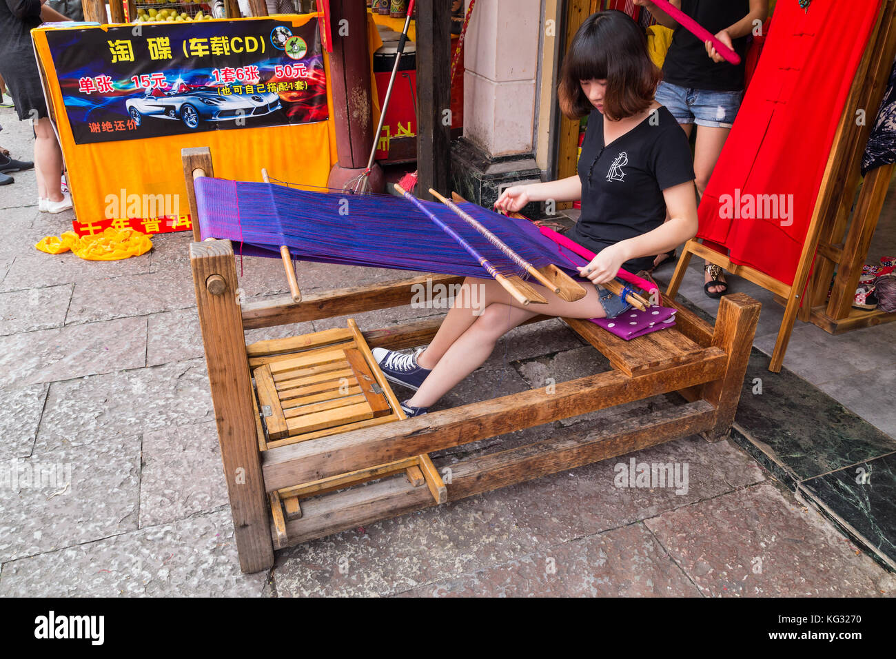 Girl weaves textile using traditional loom device Stock Photo - Alamy