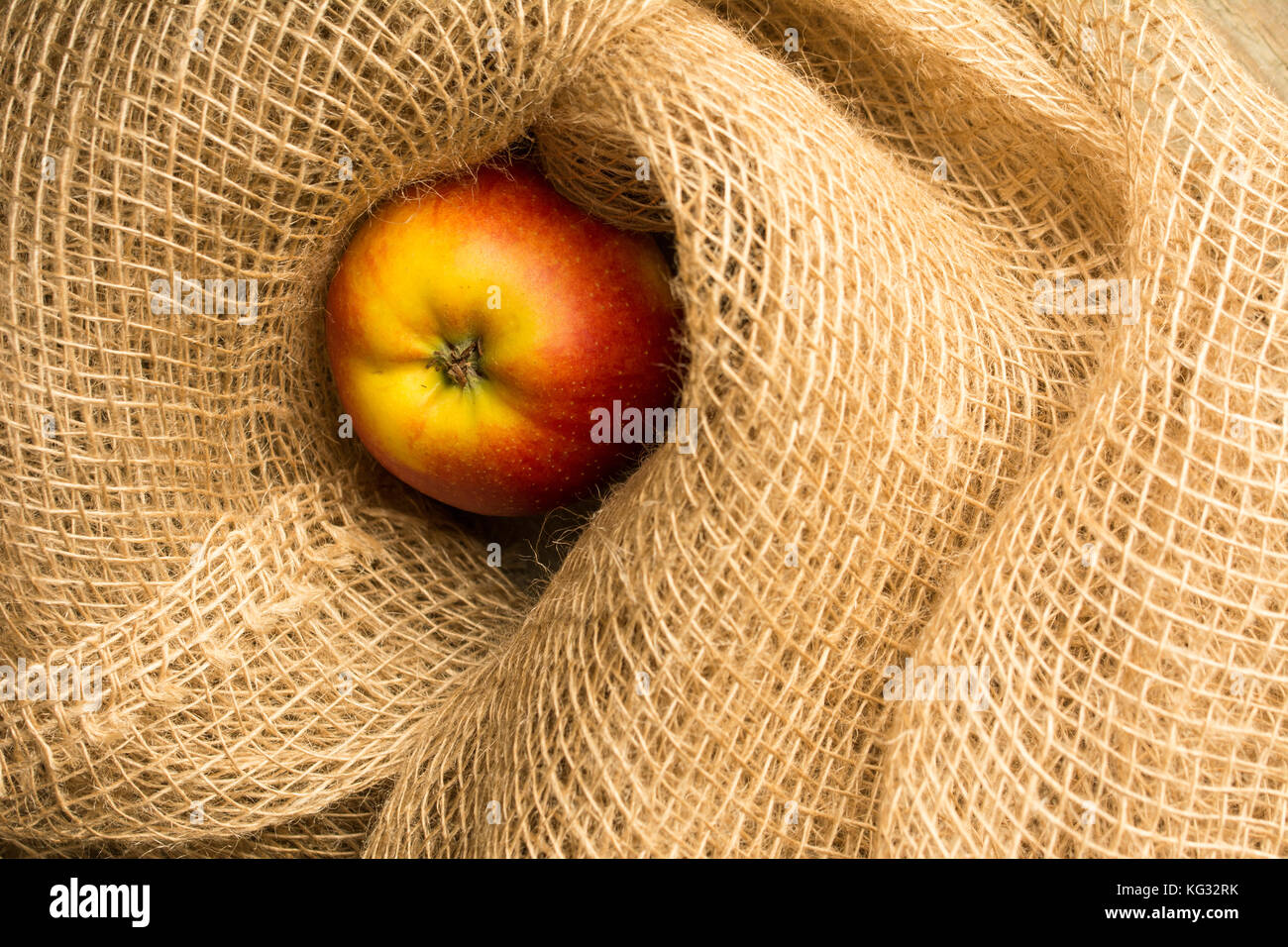 Red and yellow apple wrapped in gunny netting Stock Photo - Alamy