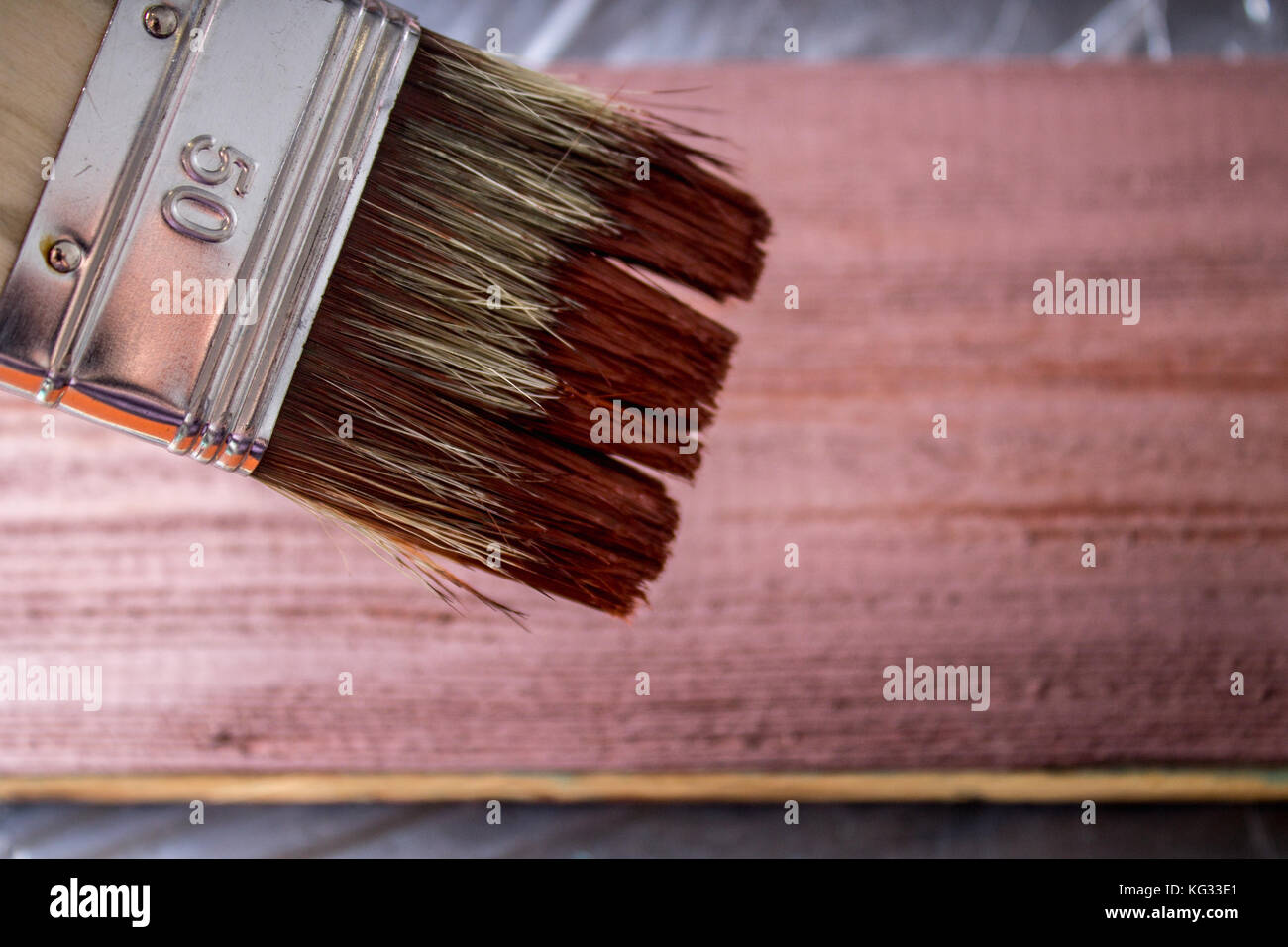Brush with paint in hand. A man paints blue boards in a brown paint ...
