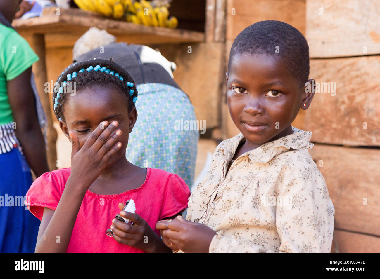 Two (2) smiling girls in front of a wooden shack Stock Photo - Alamy